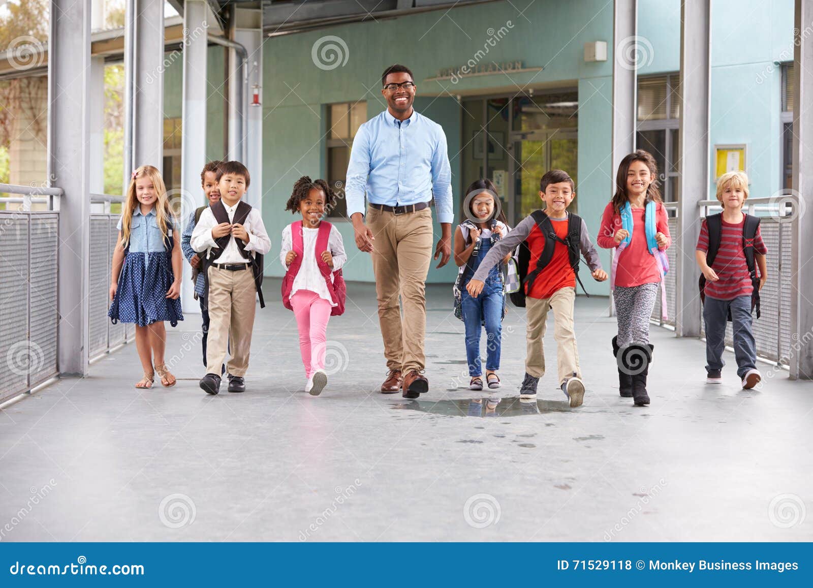 Male Teacher Walking in Corridor with Elementary School Kids Stock ...