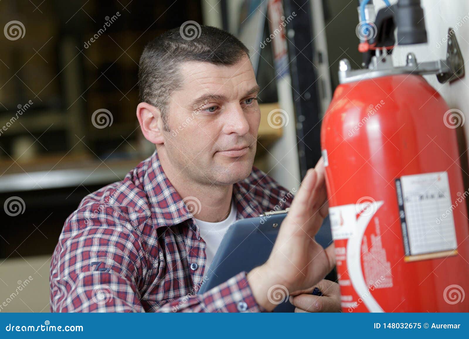 Male Technician Checking Fire Extinguisher Writing on Document Stock ...