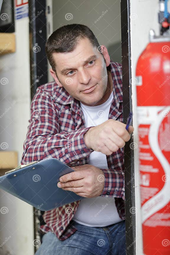 Male Technician Checking Red Fire Extinguisher Stock Image - Image of ...