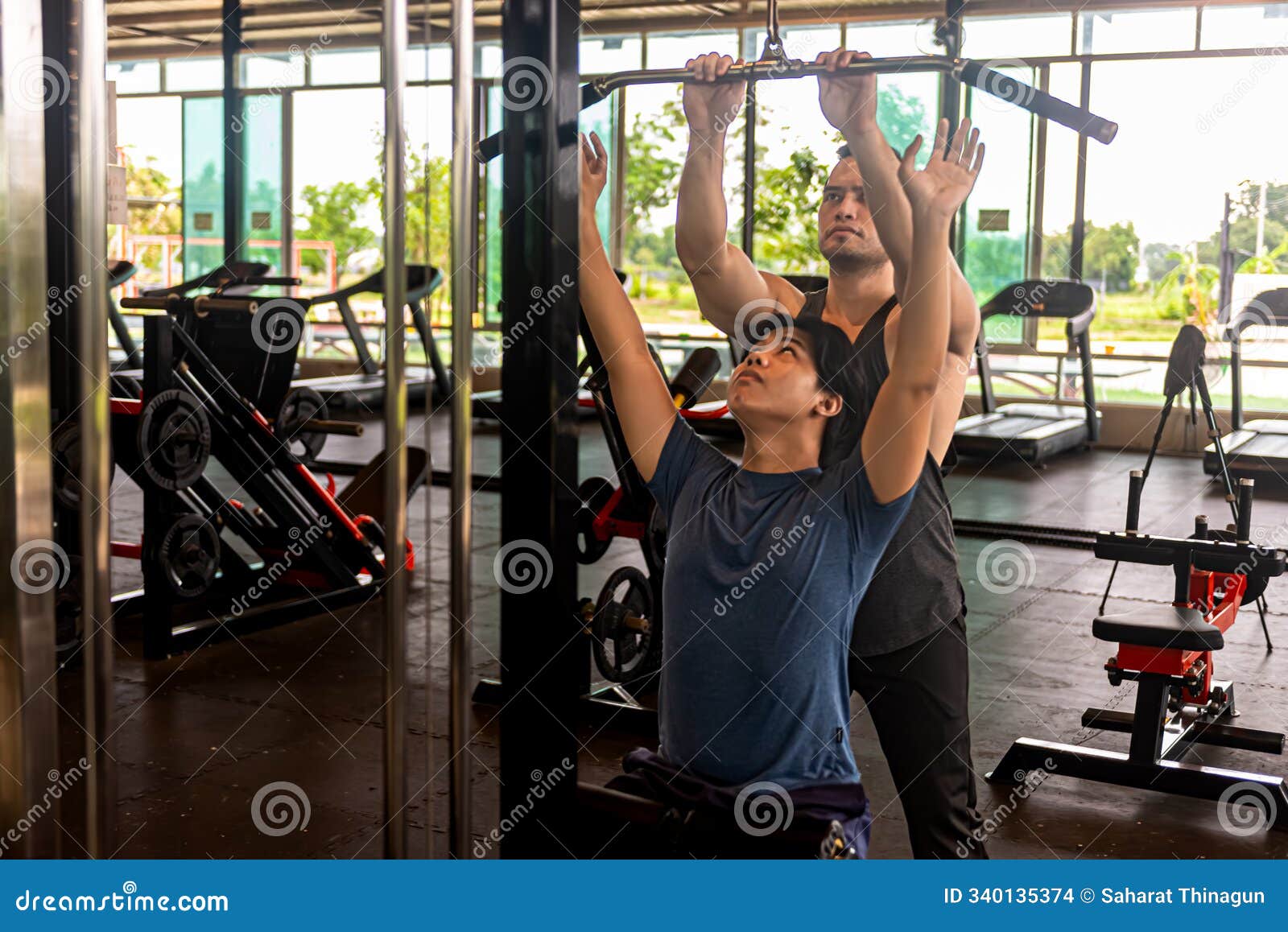 Male Trainer Assisting Trainee To Do the Correct Exercise Postures ...