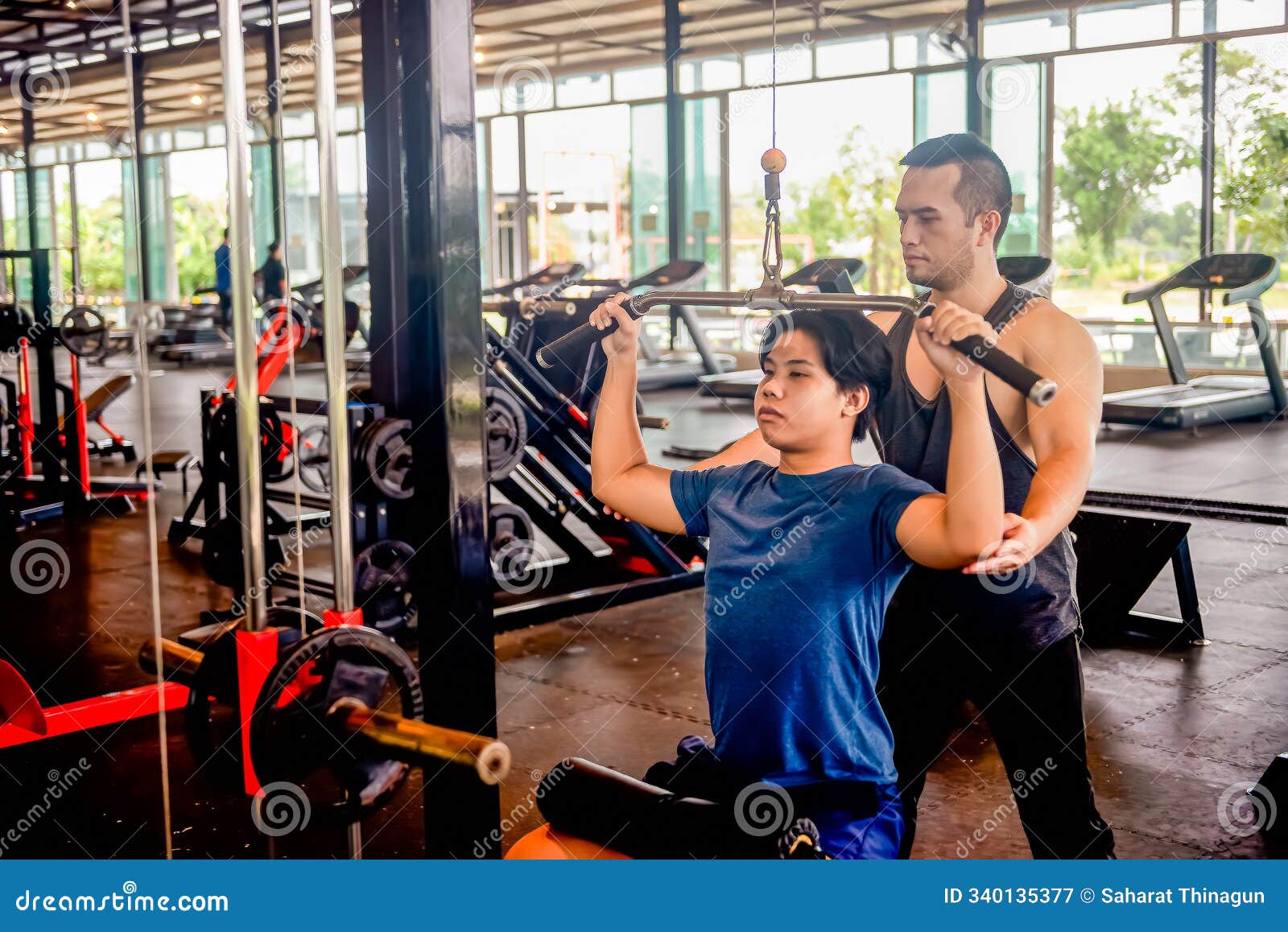 Male Trainer Assisting Trainee To Do the Correct Exercise Postures ...