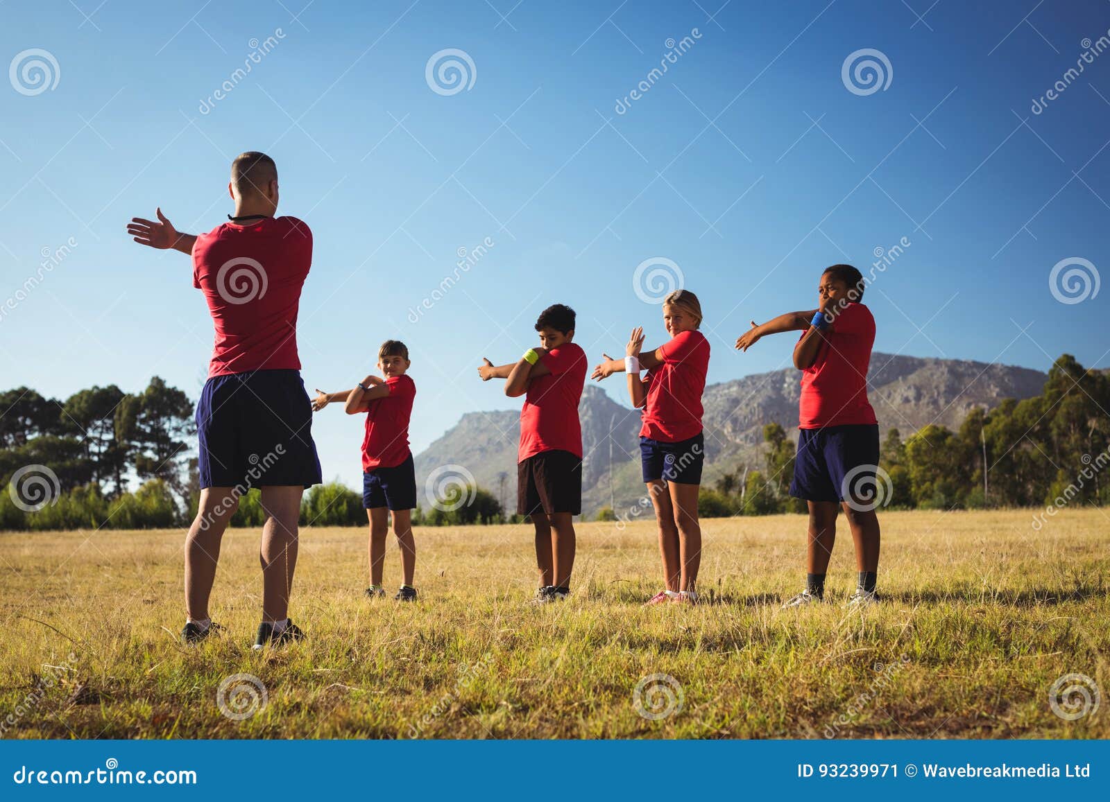 Male Trainer Instructing Kids while Exercising in the Boot Camp Stock ...