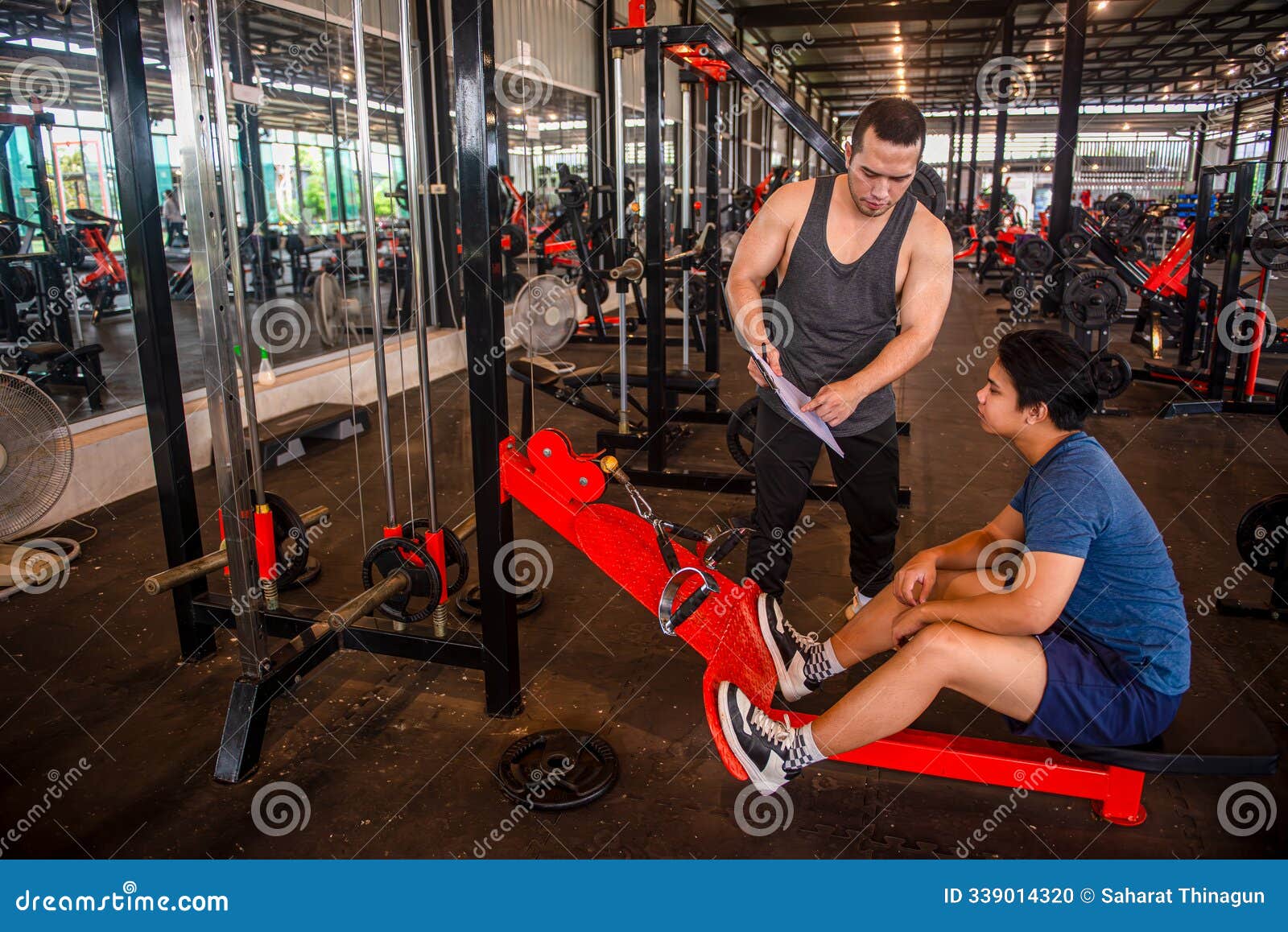 Male Trainer Shows the Exercise Program To the Trainee and Plans the ...