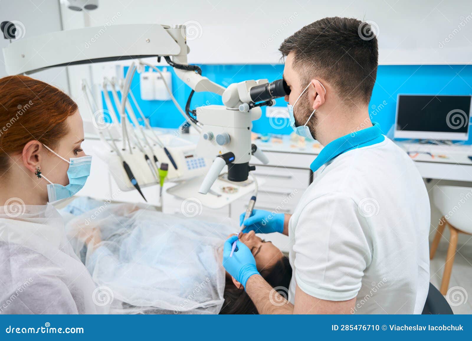 Male Treats a Patients Tooth Under a Microscope Stock Photo - Image of ...
