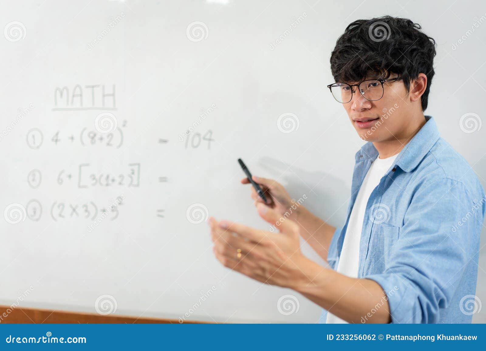 Male Tutor Standing In Front Of Whiteboard And Writing Math Equations ...