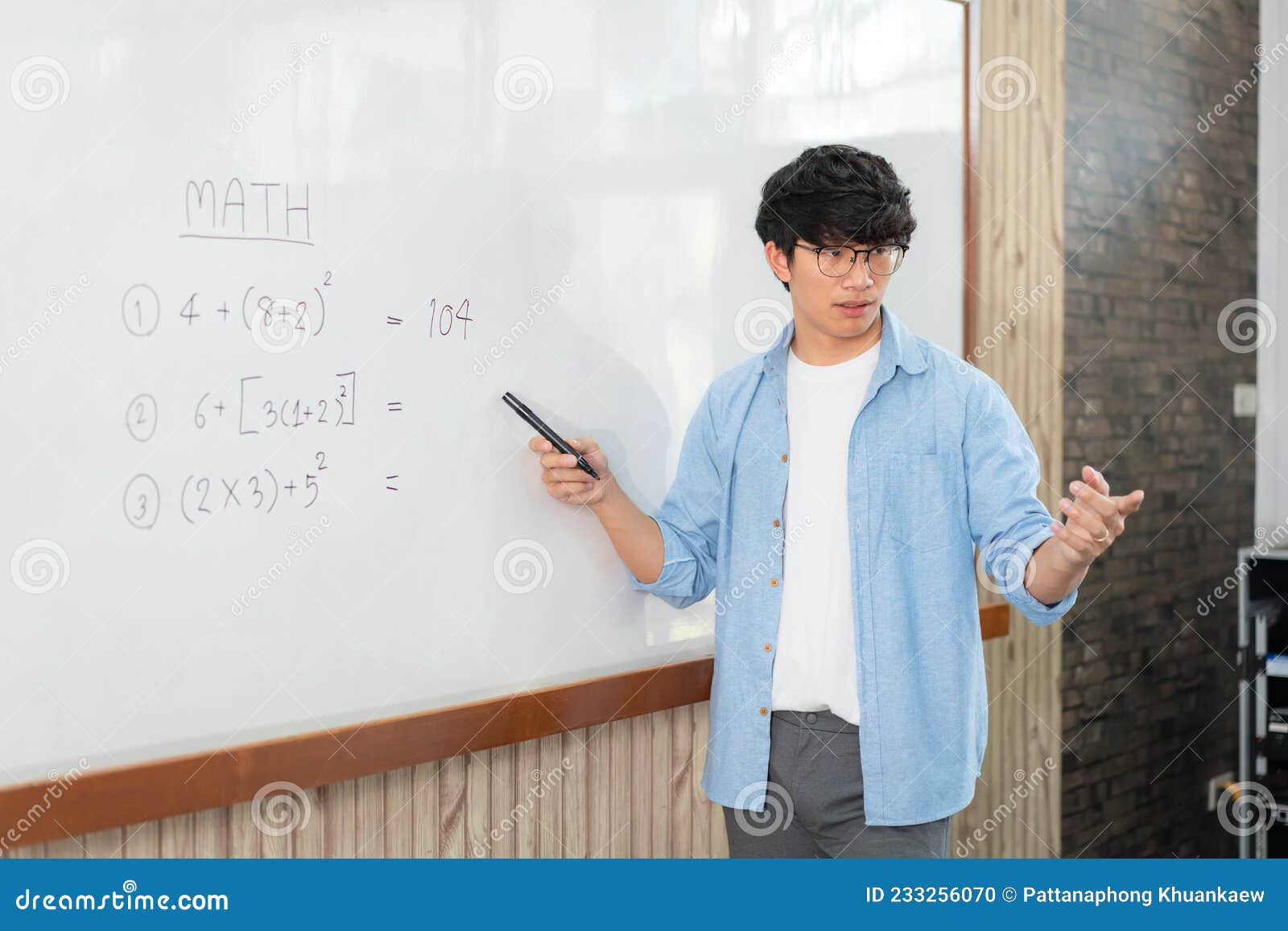 Male Tutor Standing in Front of Whiteboard and Writing Math Equations ...