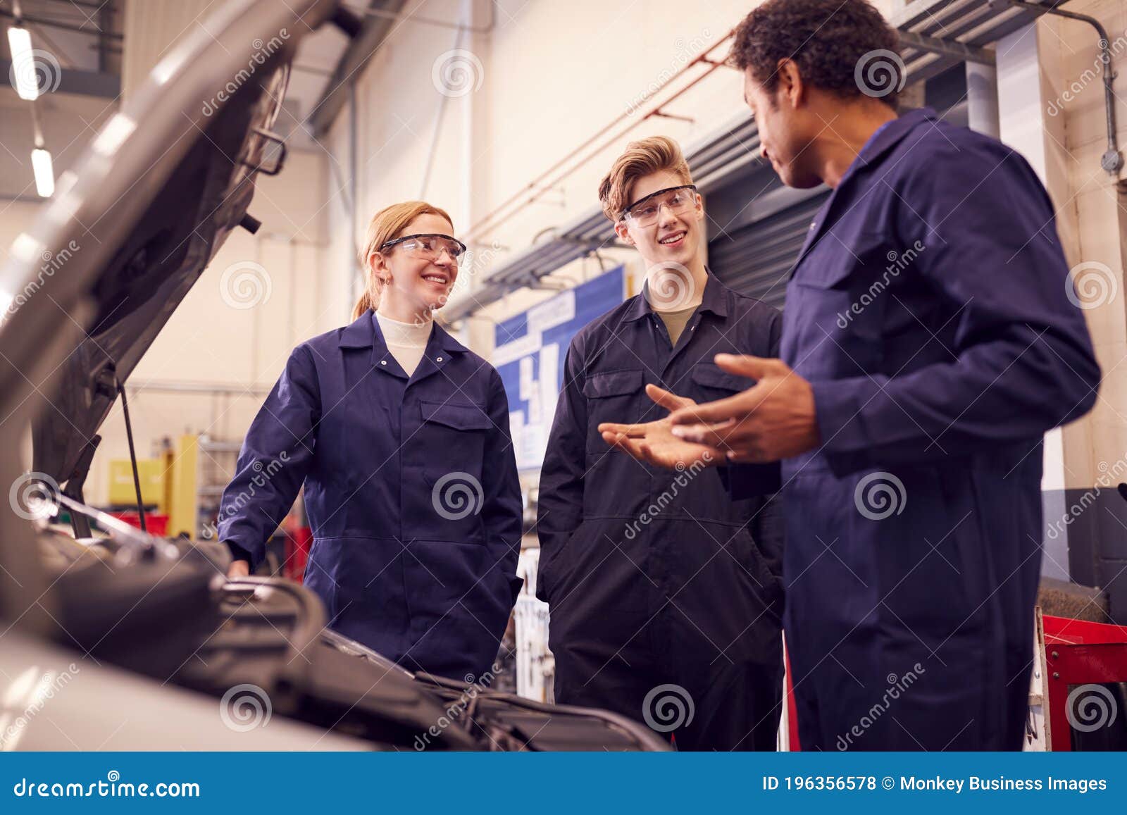 Male Tutor with Students Looking at Car Engine on Auto Mechanic ...