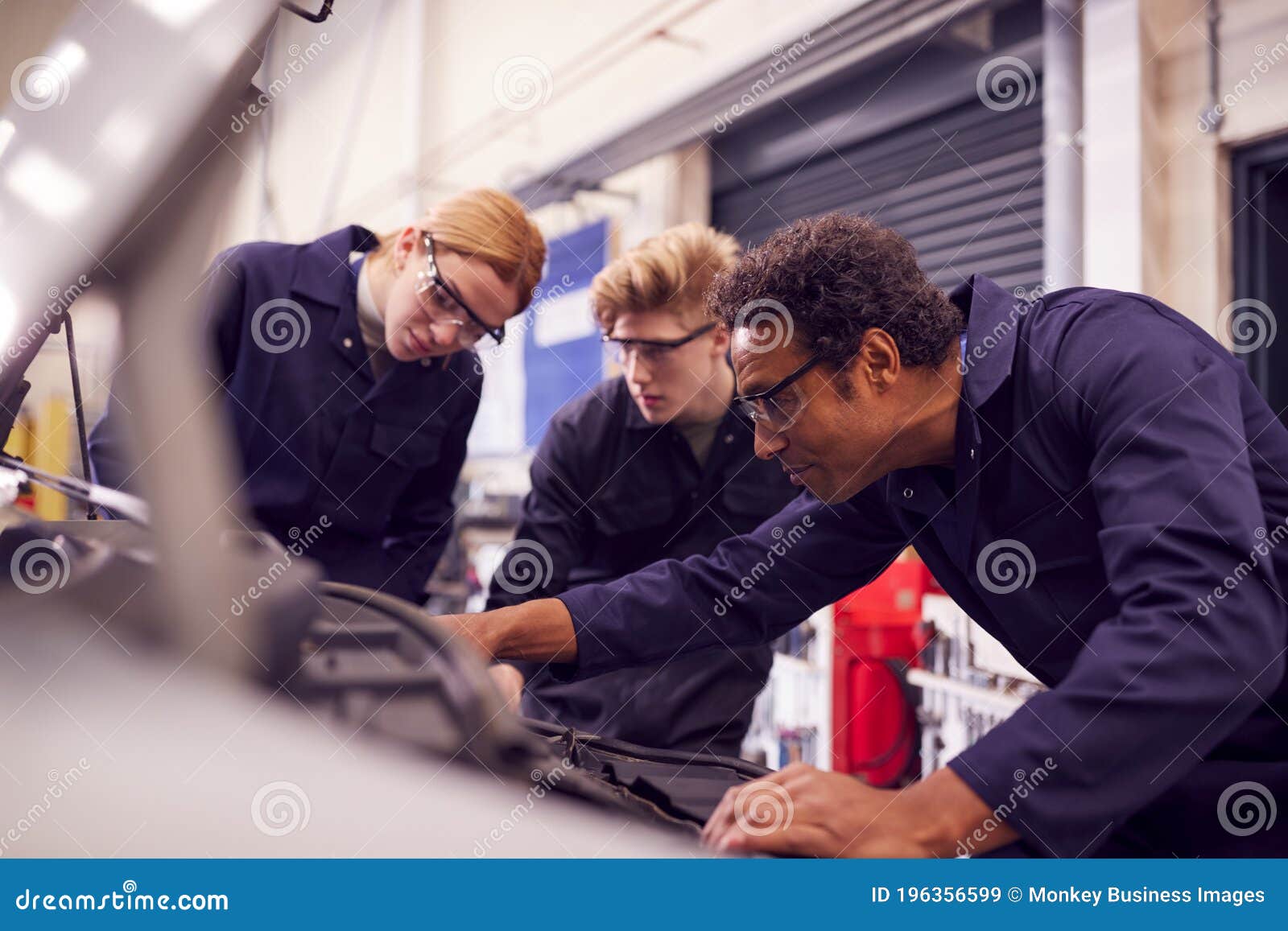 Male Tutor with Students Looking at Car Engine on Auto Mechanic ...