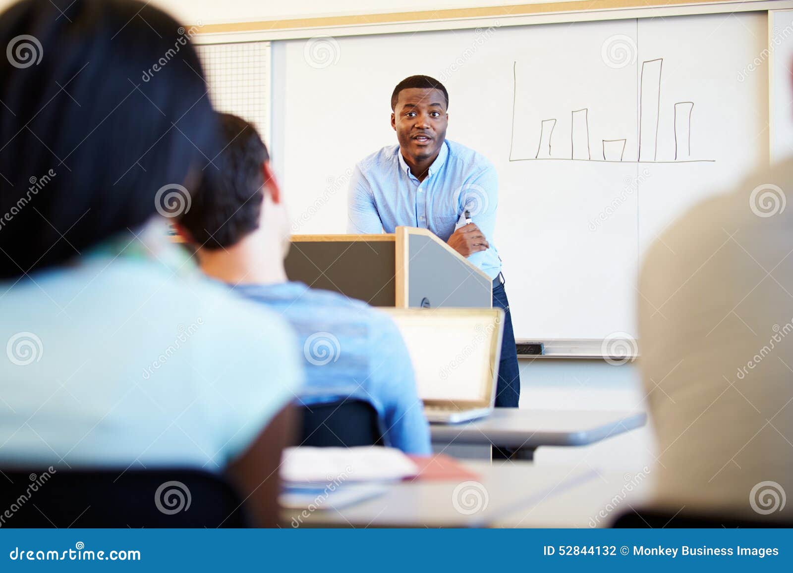 Male Tutor Teaching University Students in Classroom Stock Photo ...