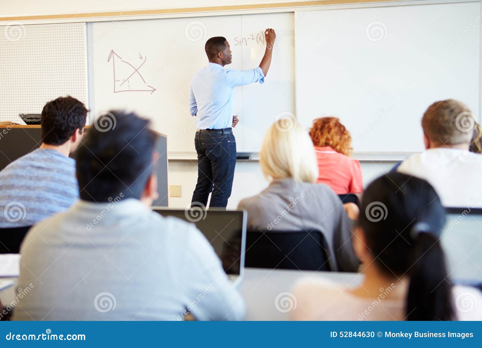 Male Tutor Teaching University Students in Classroom Stock Photo ...