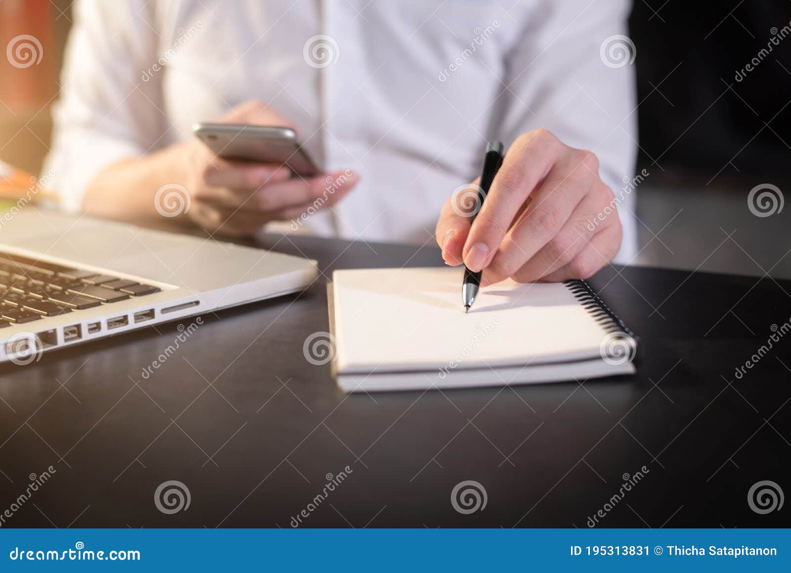 Male Use a Smartphone and Take Notes in the Notebook at the Office Desk ...