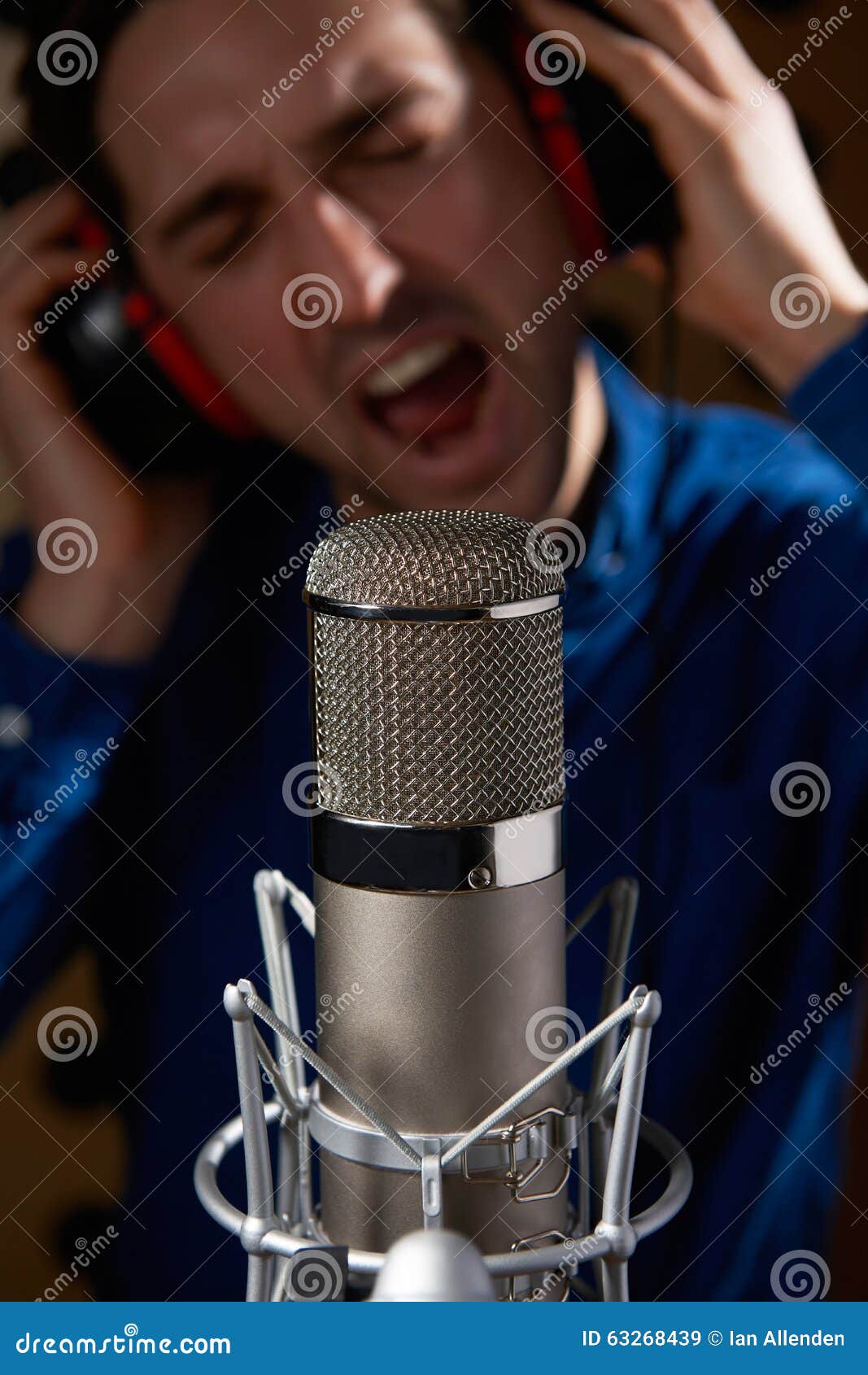 Male Vocalist Singing Into Microphone In Recording Studio. Creating New ... Male Vocalist Singing Into Microphone In Recording Studio. Creating New ...
