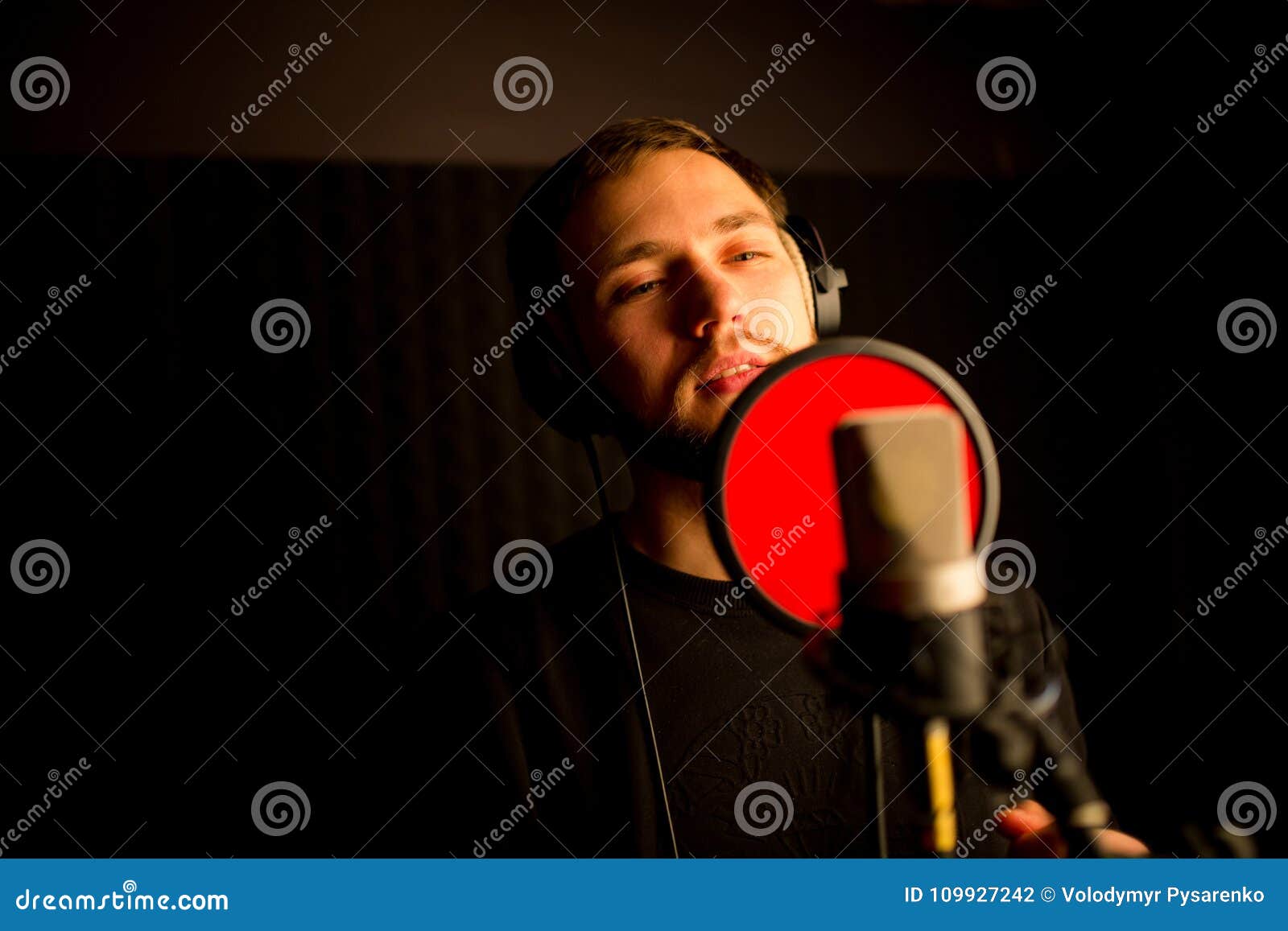Male Vocalist Singing Into Microphone In Recording Studio. Creating New ... Male Vocalist Singing Into Microphone In Recording Studio. Creating New ...