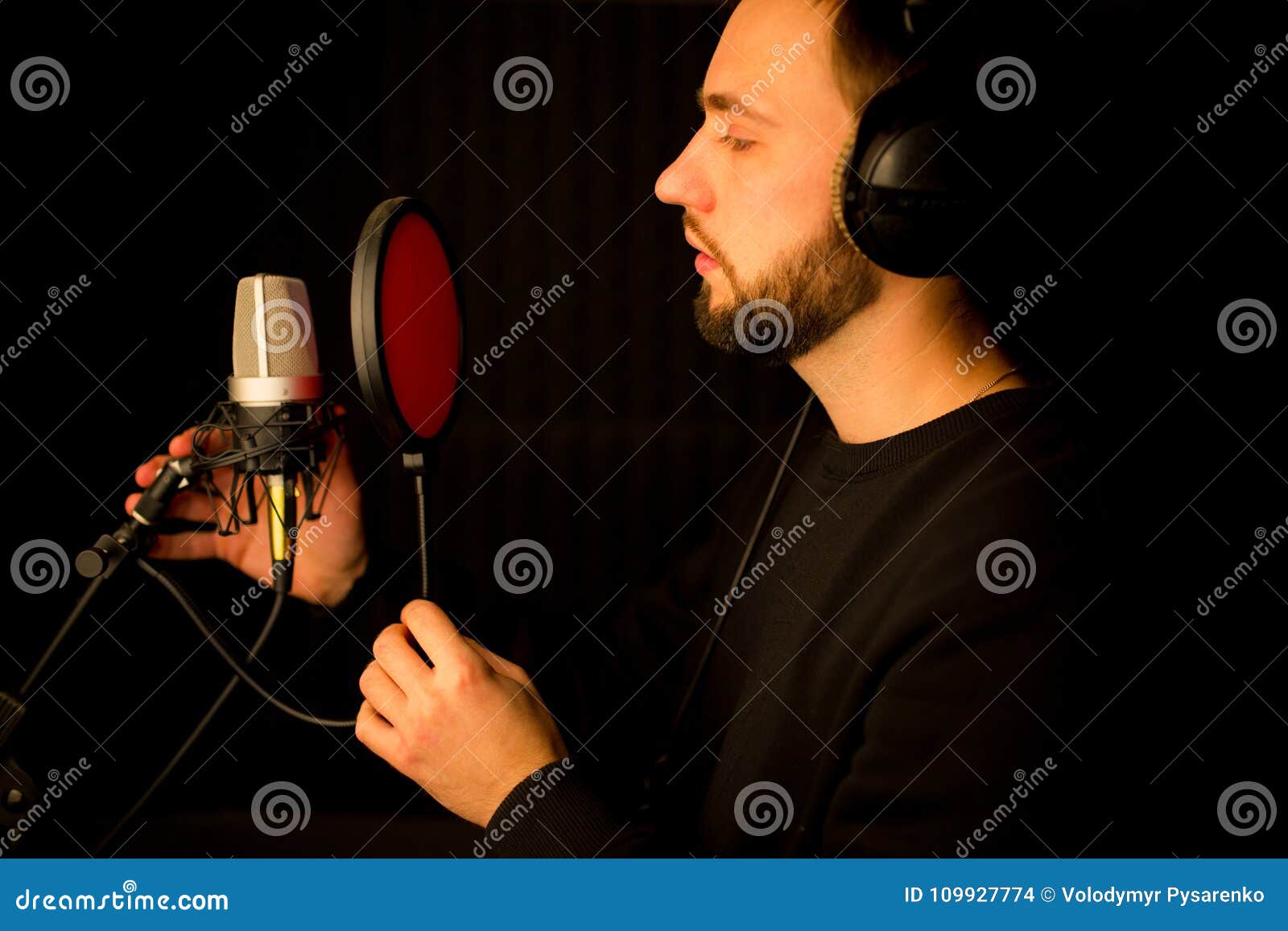 Male Vocalist Singing into Microphone in Recording Studio. Creating New ... Male Vocalist Singing into Microphone in Recording Studio. Creating New ...