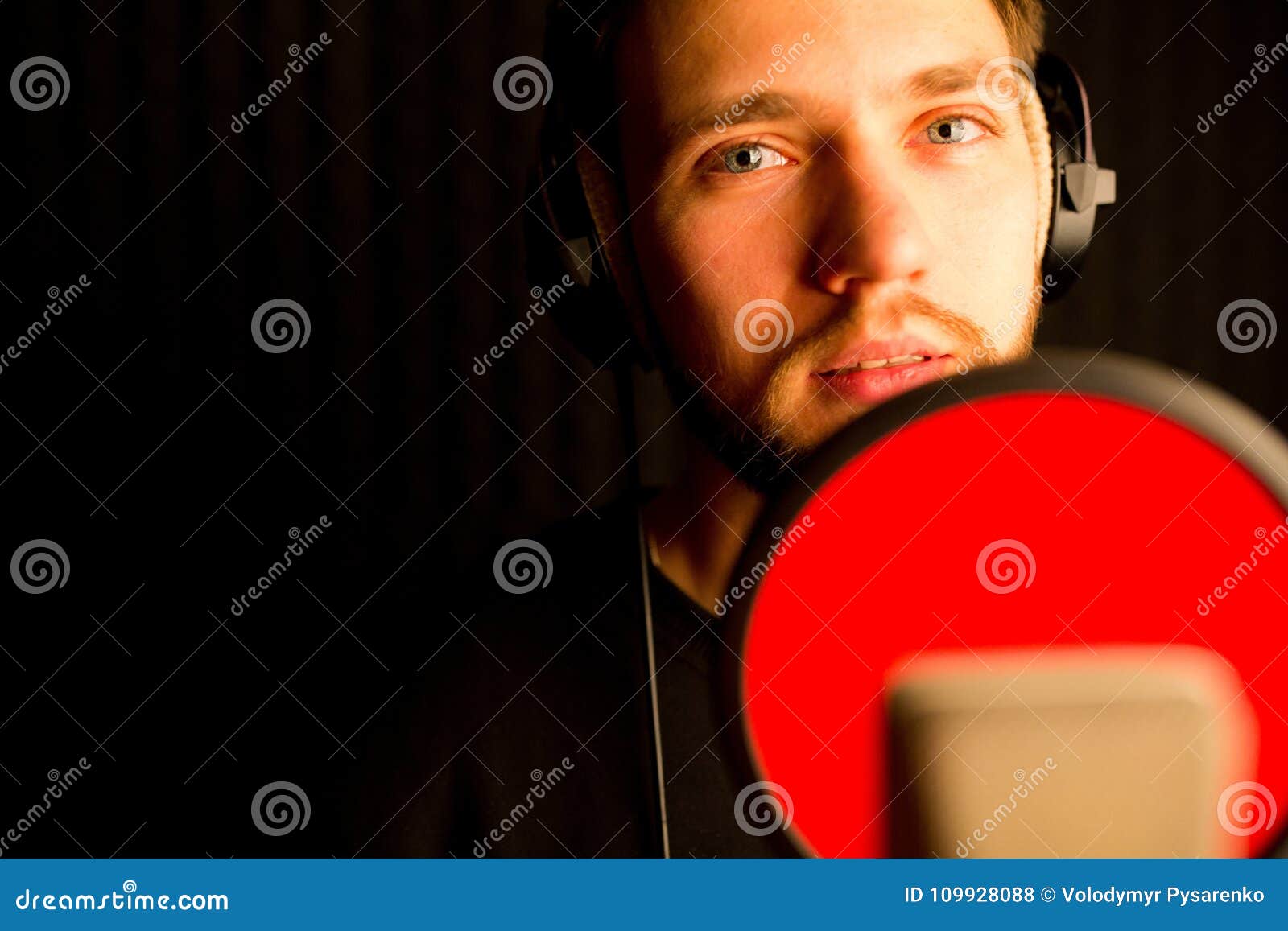 Male Vocalist Singing into Microphone in Recording Studio. Creating New ... Male Vocalist Singing into Microphone in Recording Studio. Creating New ...