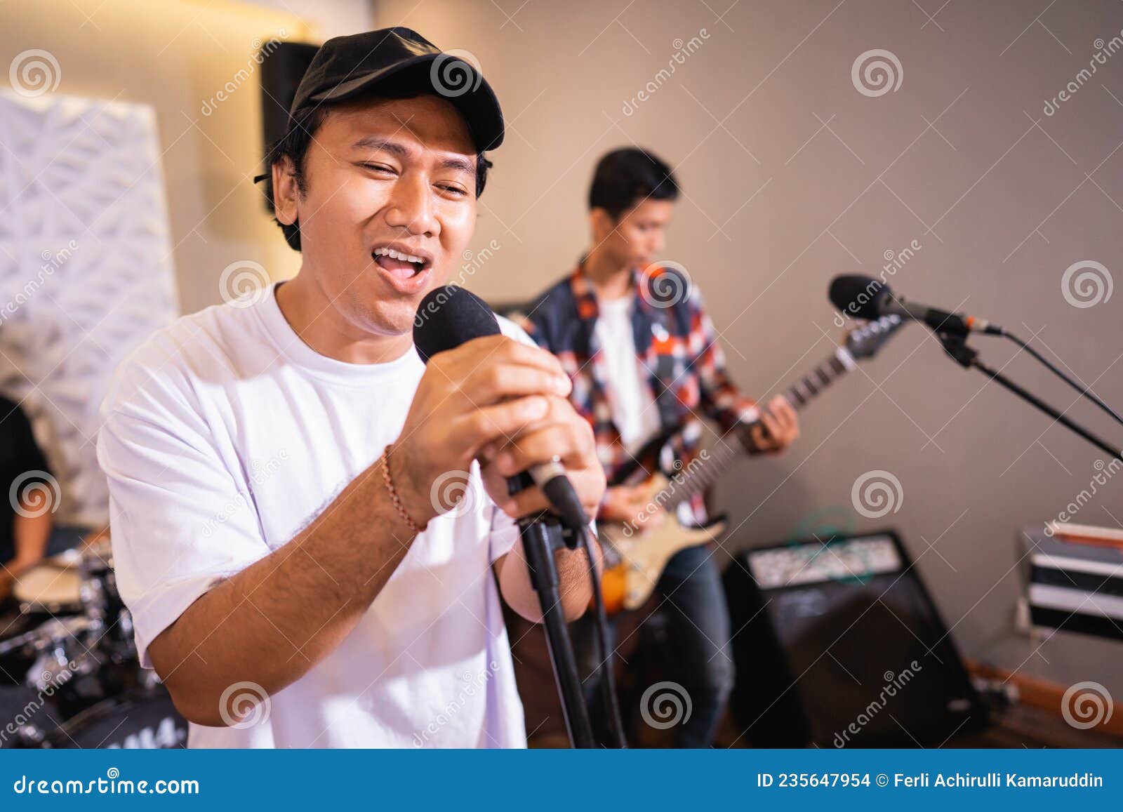Male Vocalist Singing Into Microphone In Recording Studio. Creating New ... Male Vocalist Singing Into Microphone In Recording Studio. Creating New ...