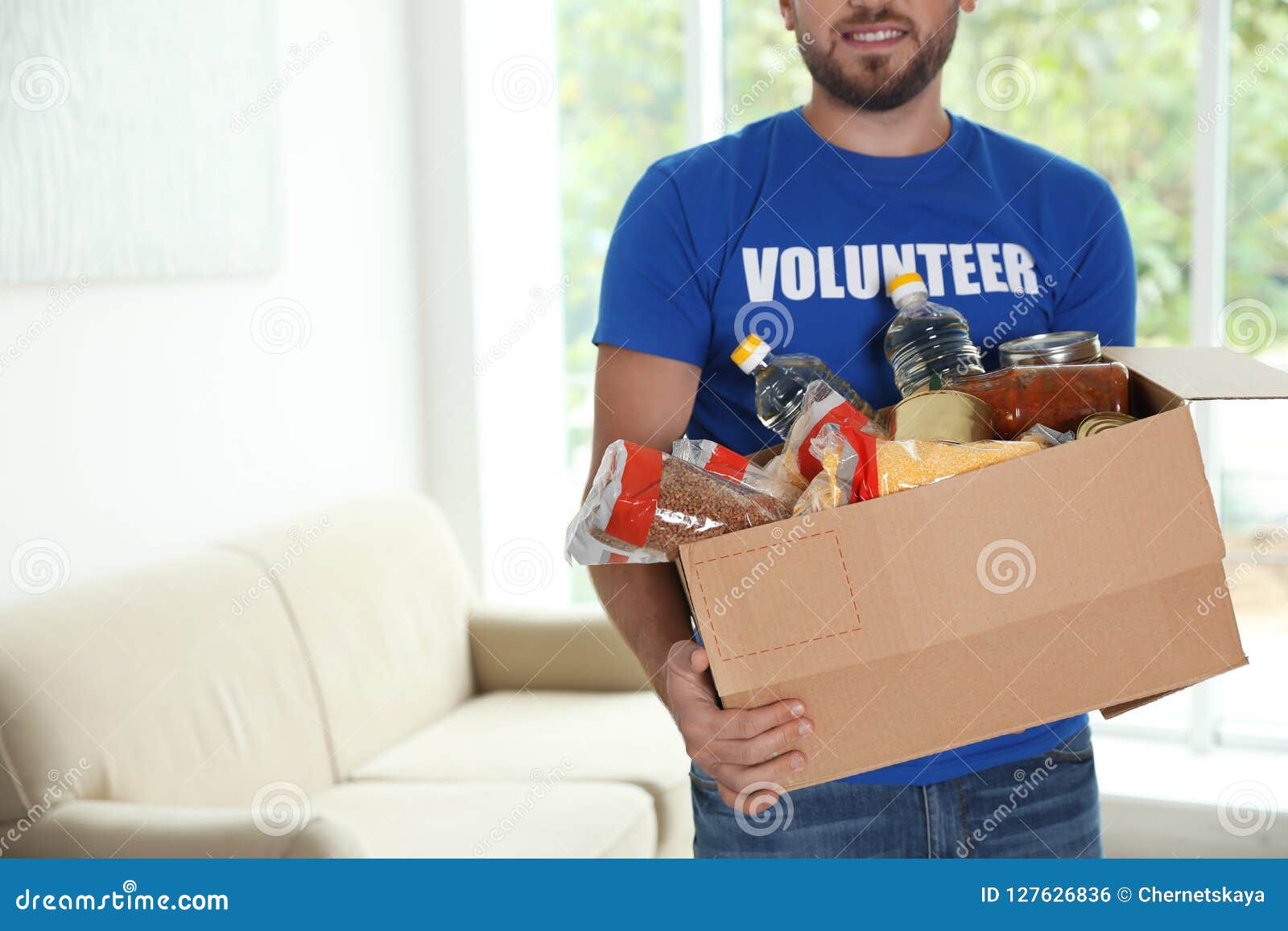 Male Volunteer Holding Box with Donations Indoors Stock Photo - Image ...