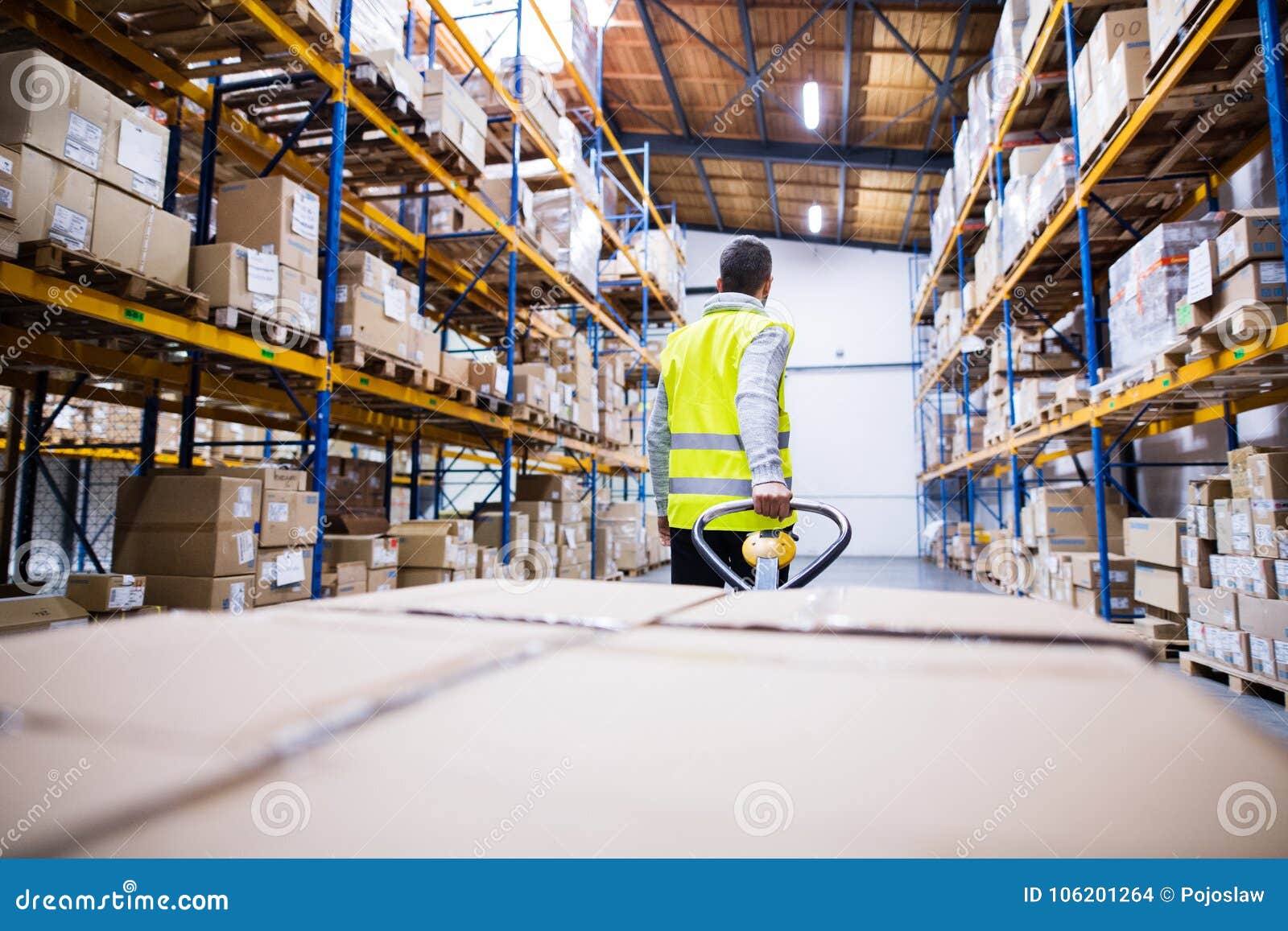 Male Warehouse Worker Pulling a Pallet Truck. Stock Photo - Image of ...