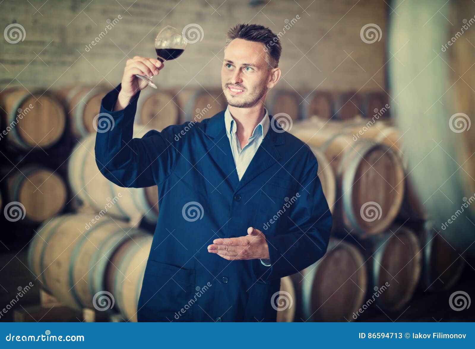 Male Winemaker in Uniform Having Glass of Wine in Hands in Cell Stock ...