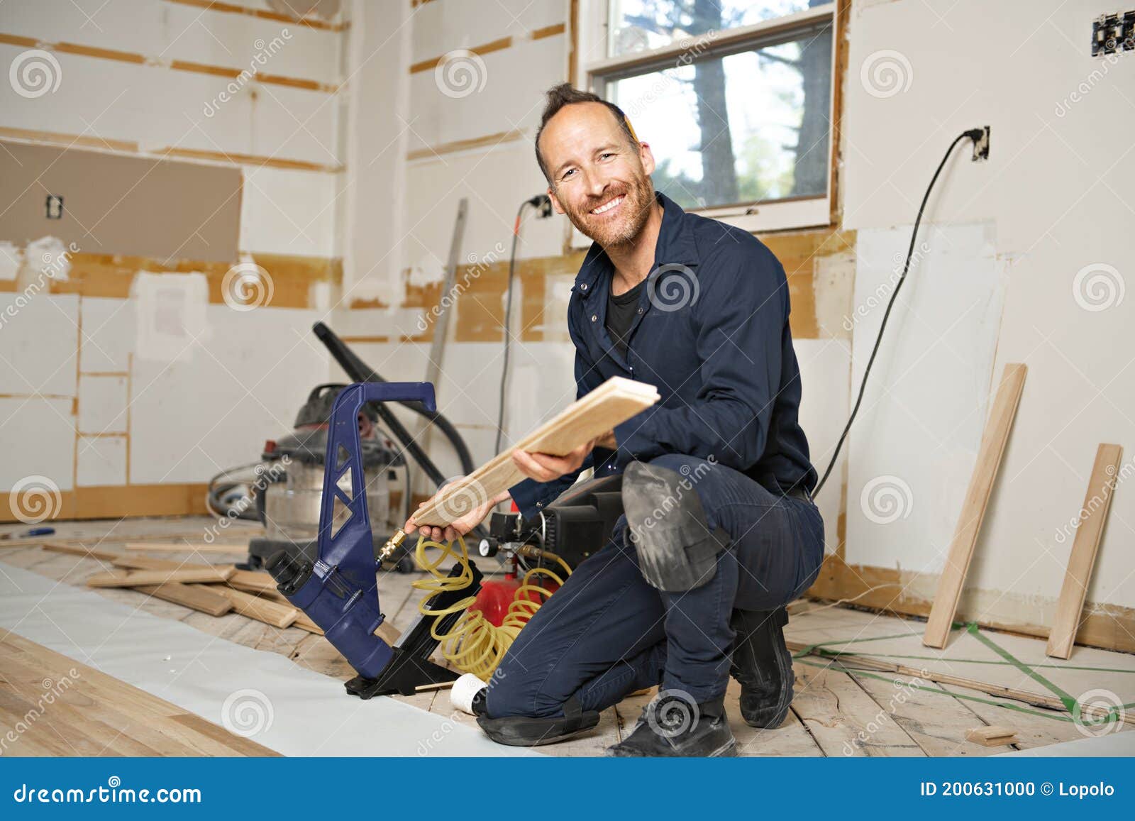 A Male Worker Install Wood Floor on a House Stock Photo - Image of ...