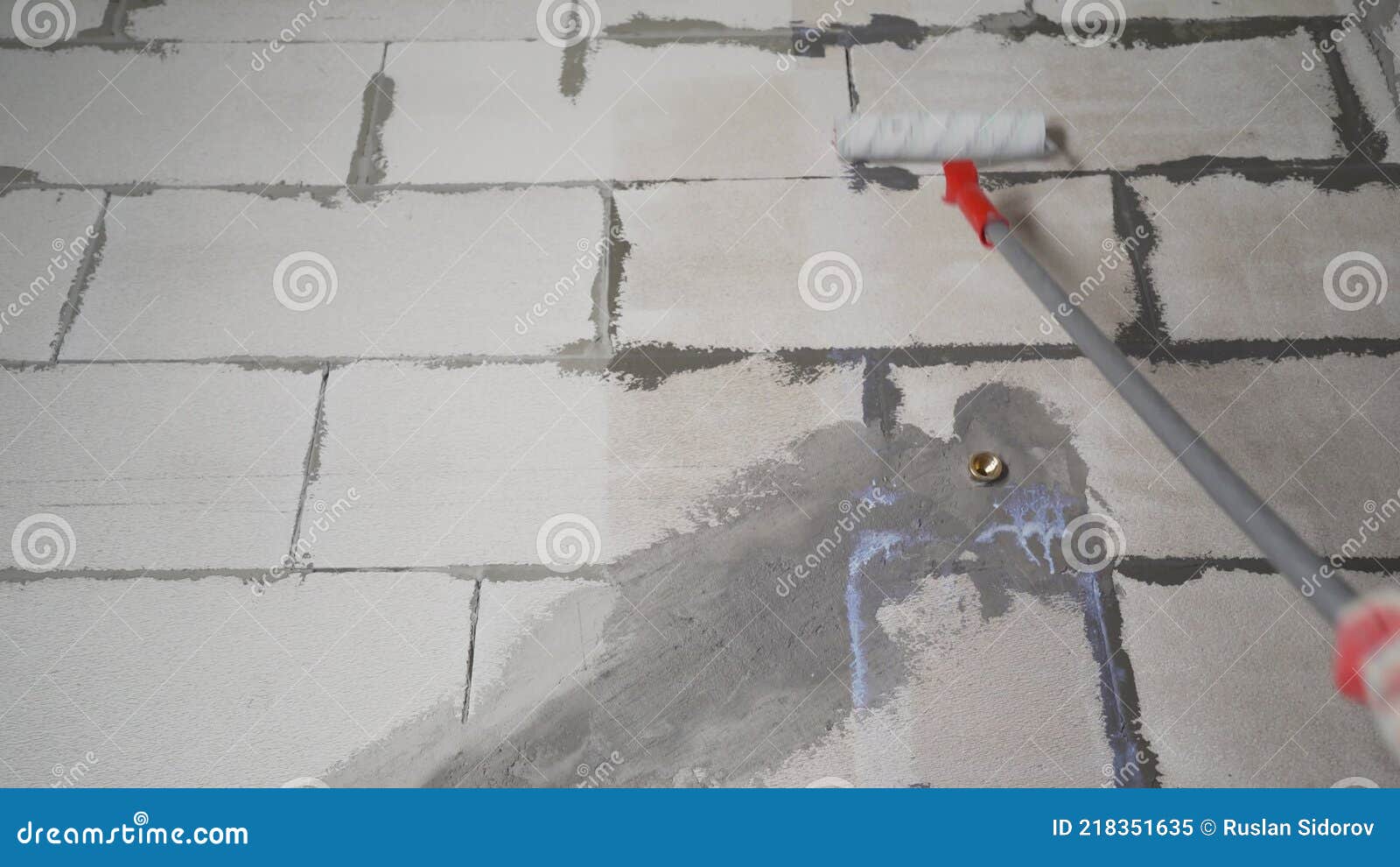 A Male Worker Paints the Wall with a Roller for Better Adhesion of the ...