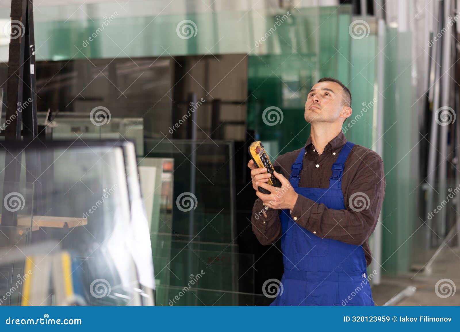 Male Worker Using Control Panel and Lifting Mechanism Controls Movement ...