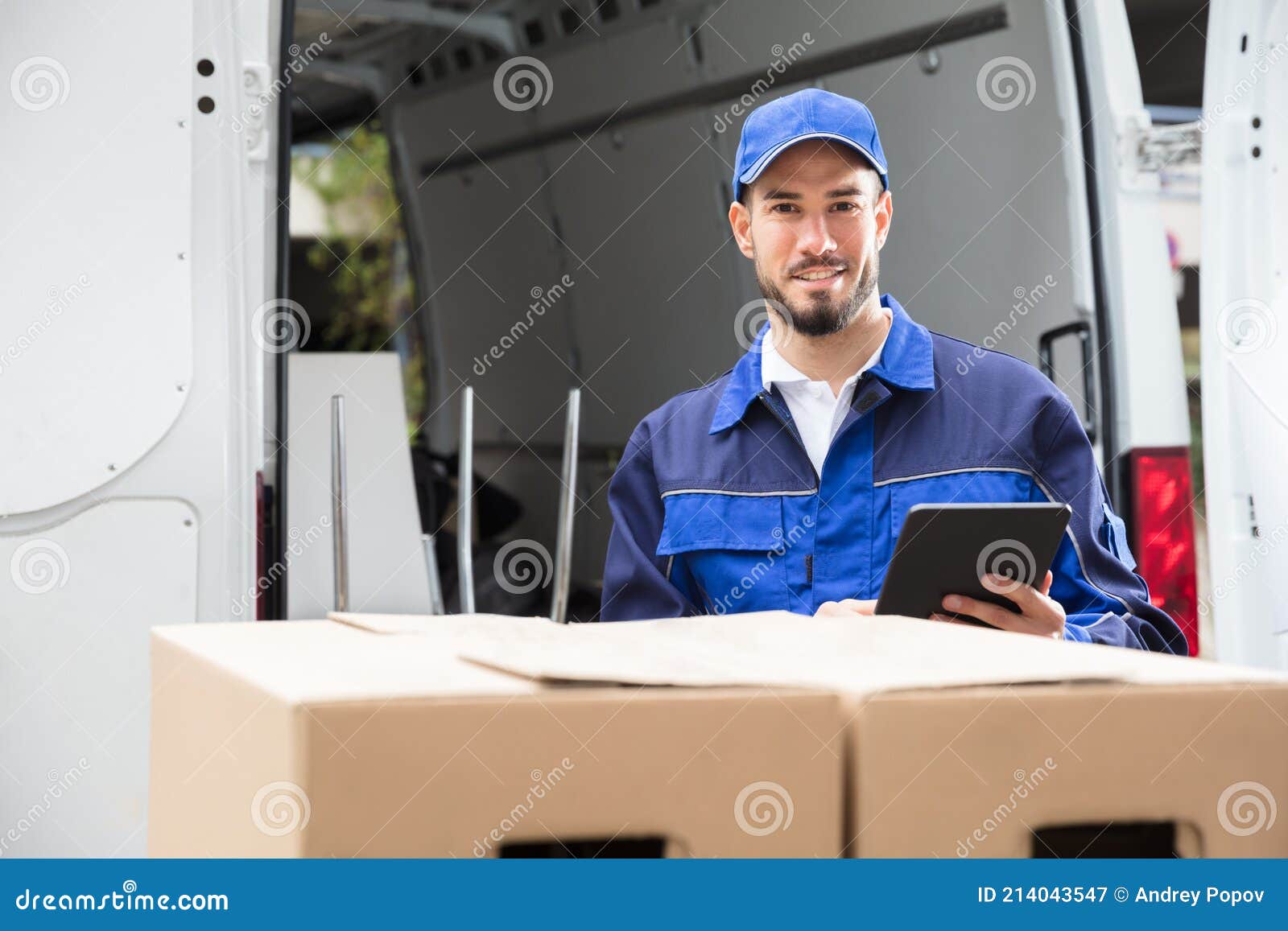 Male Worker Using Tablet stock image. Image of boxes - 214043547