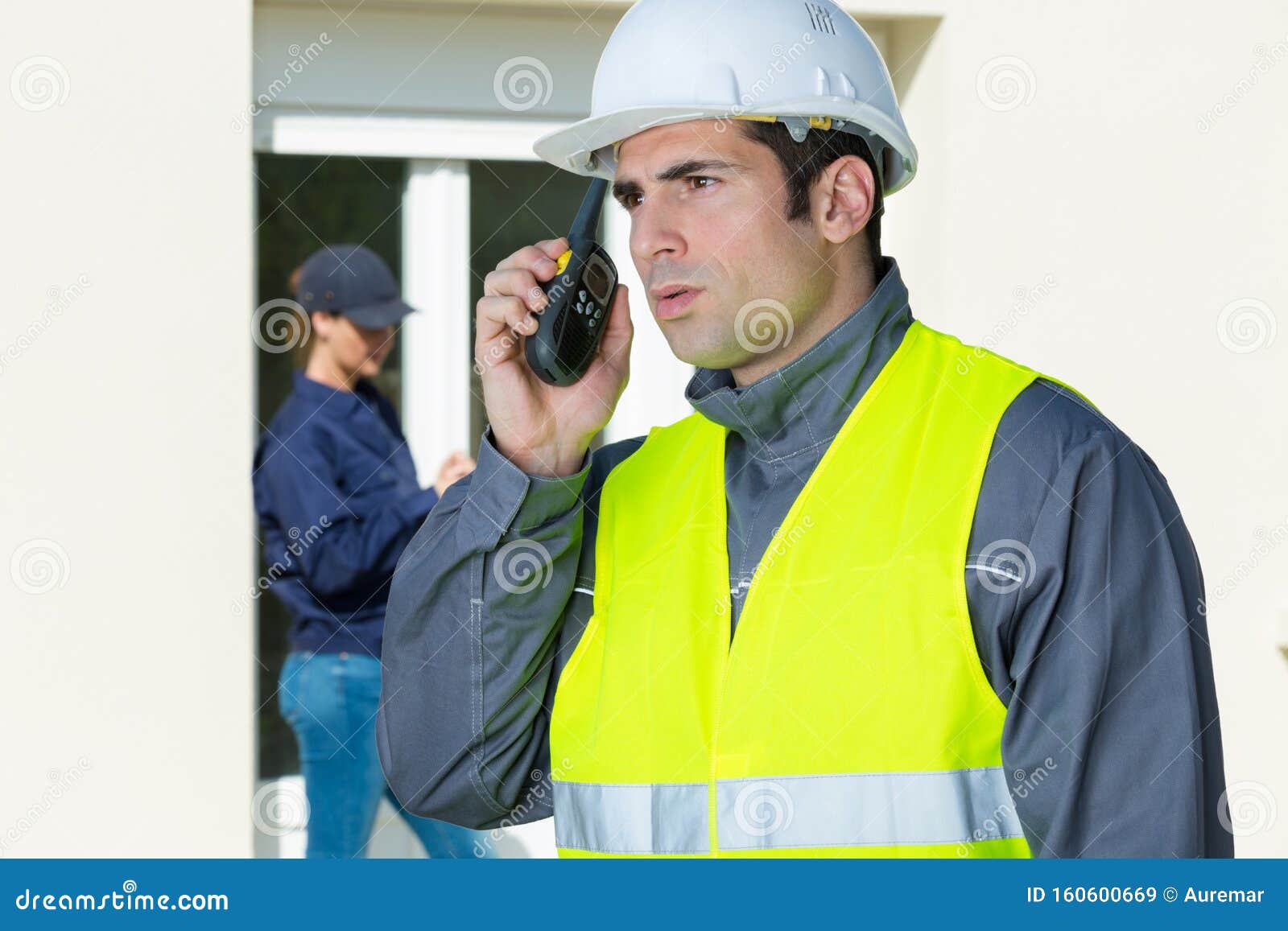 Male Worker Using Walkie-talkie with Colleague in Background Stock ...