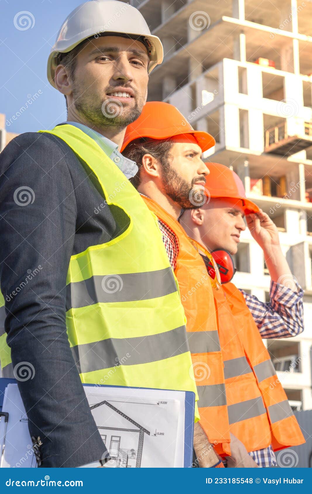 Male Workers Engineers at Construction Site in Helmets Hardhats. High ...