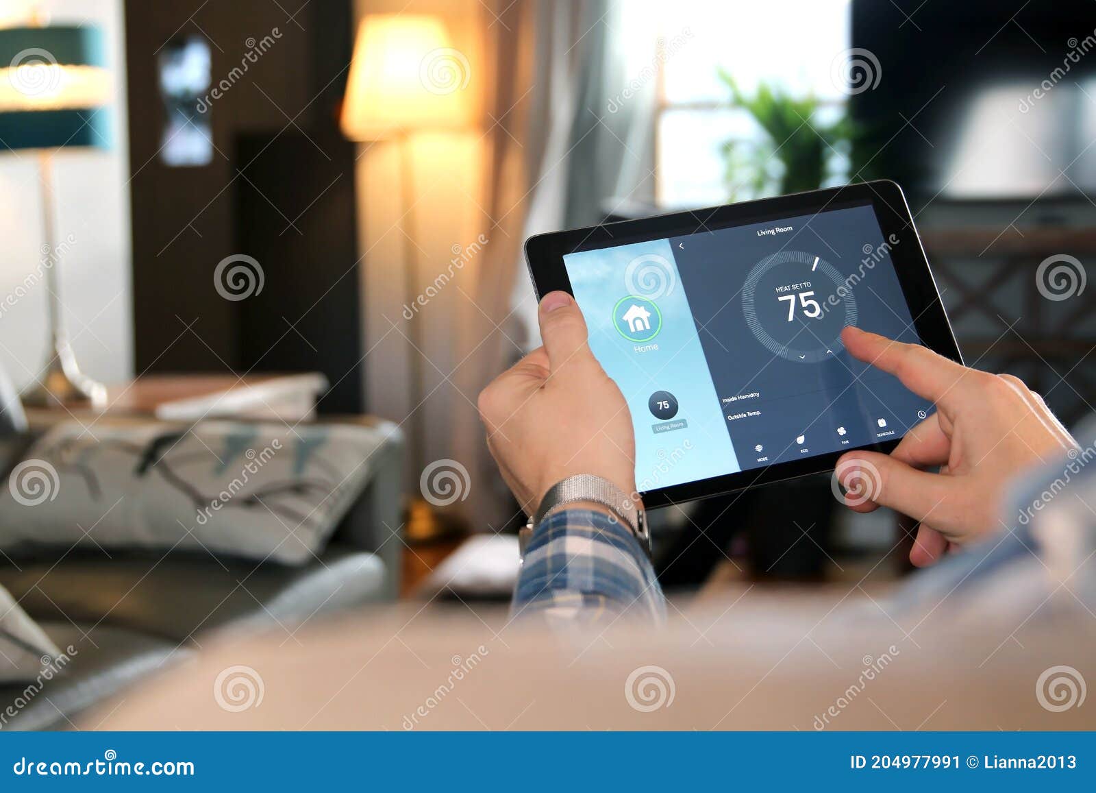 Man is Adjusting a Temperature Using a Tablet with Smart Home App in ...