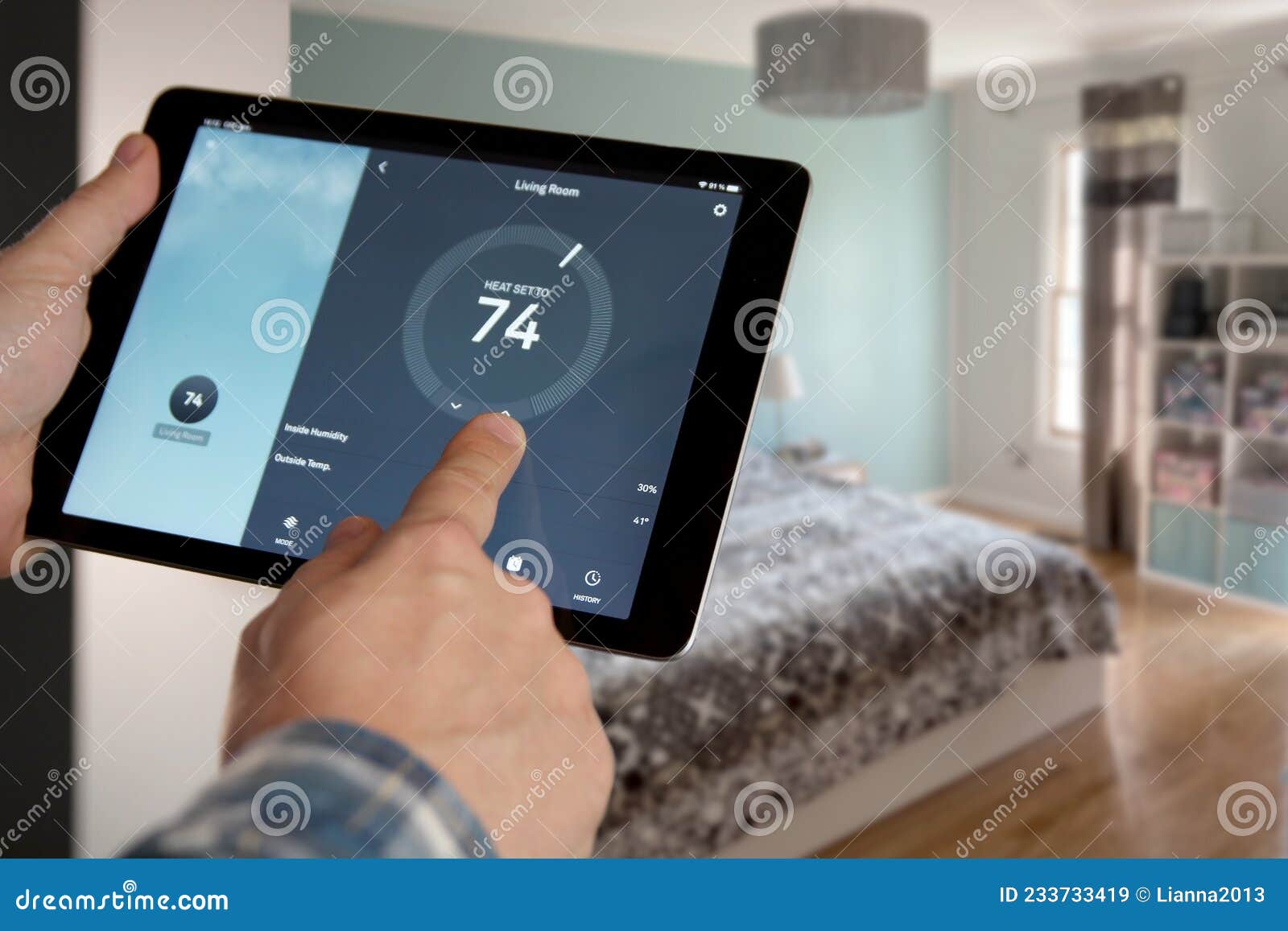 Man is Adjusting a Temperature Using a Tablet with Smart Home App in ...