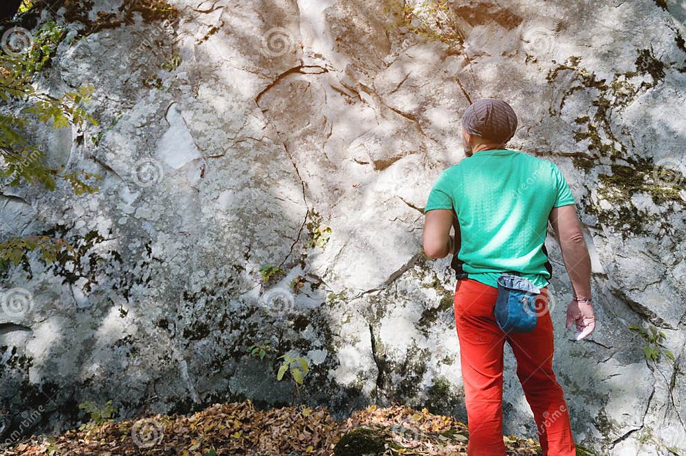 A Man Aged Climber Stands in Front of a Training Rock in the Forest ...