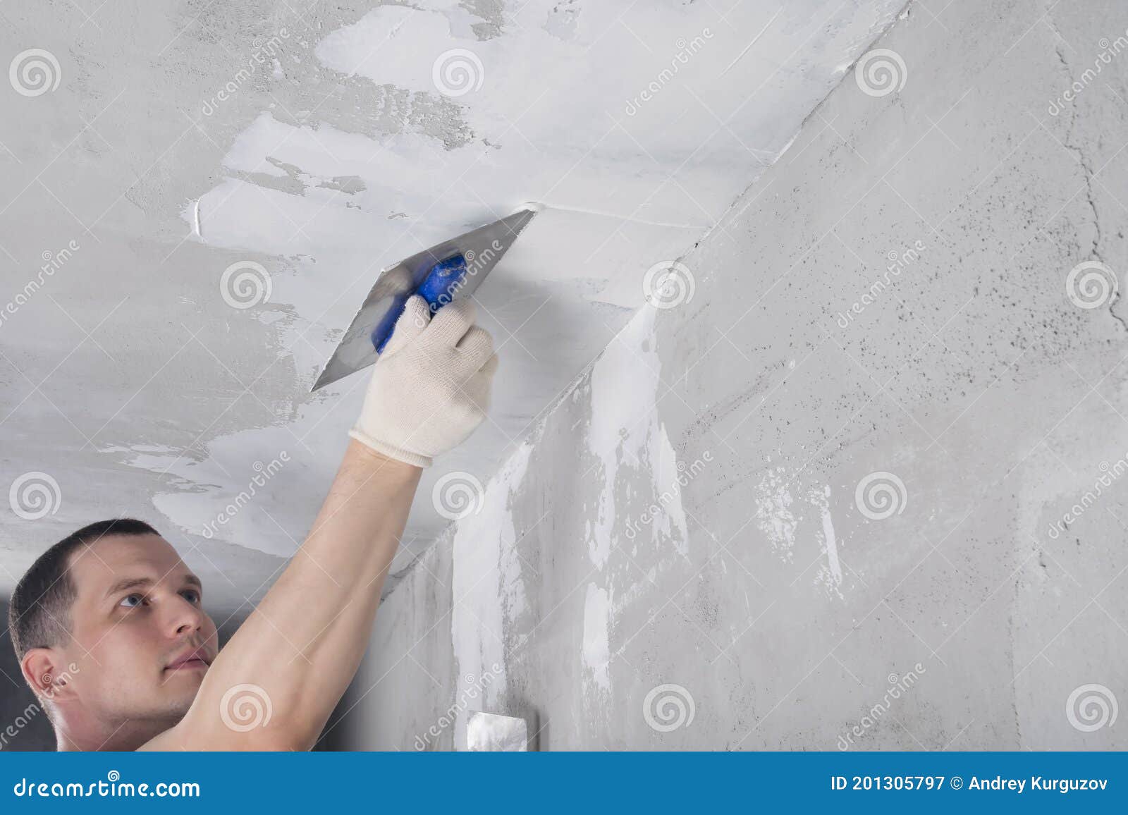 A Man Applies a Mortar To the Ceiling with a Spatula To Level it Stock ...