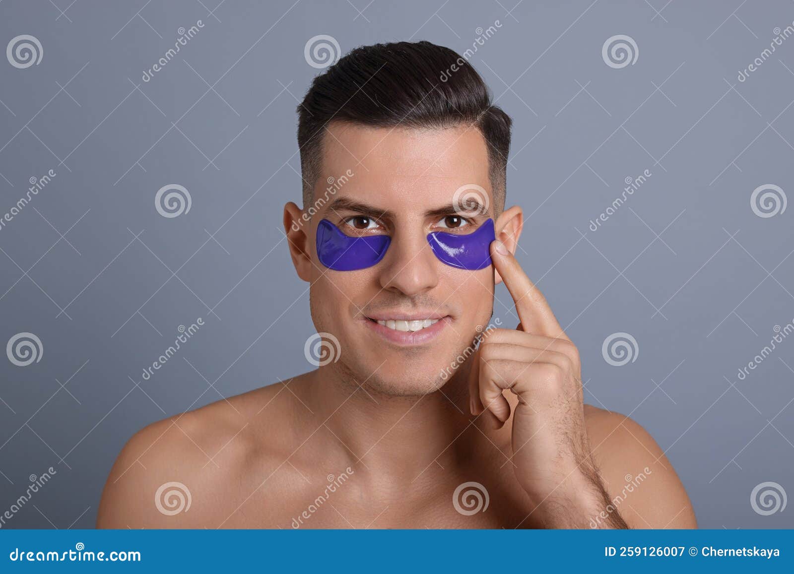 Man Applying Blue Under Eye Patch on Grey Background Stock Image ...