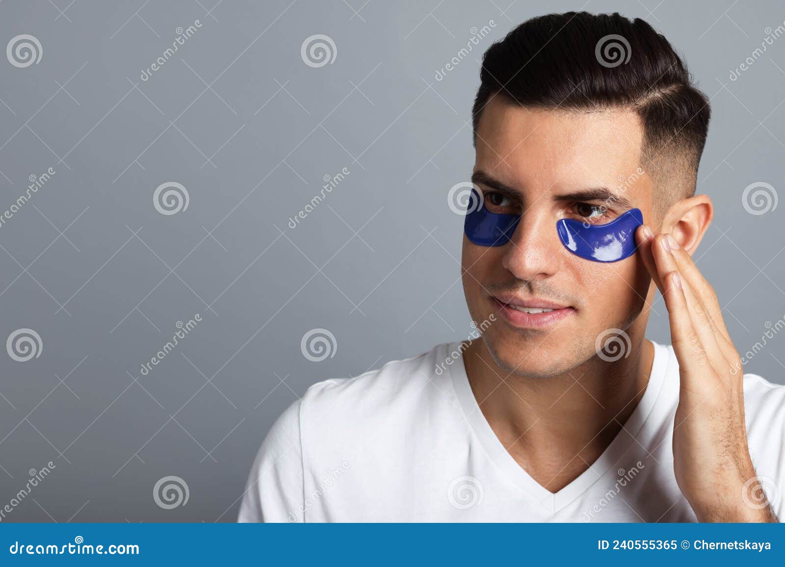 Man Applying Blue Under Eye Patch on Grey Background. Space for Text ...