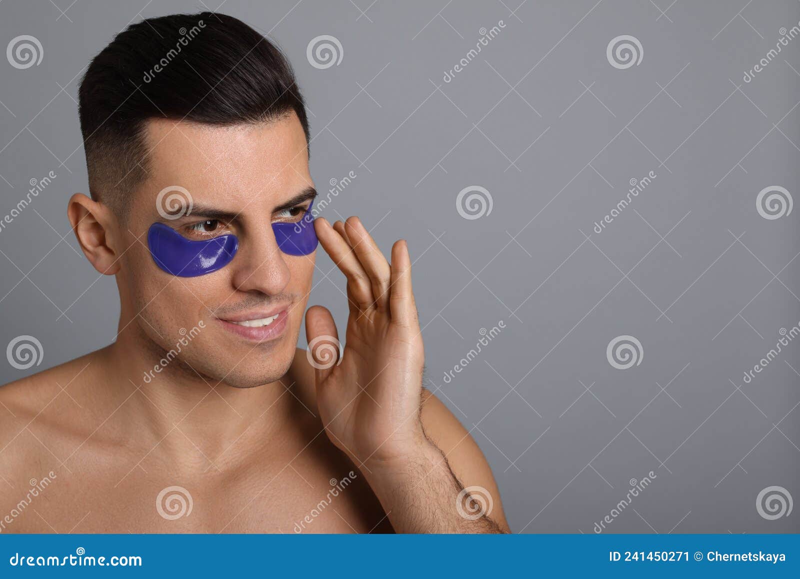 Man Applying Blue Under Eye Patch on Grey Background. Space for Text ...