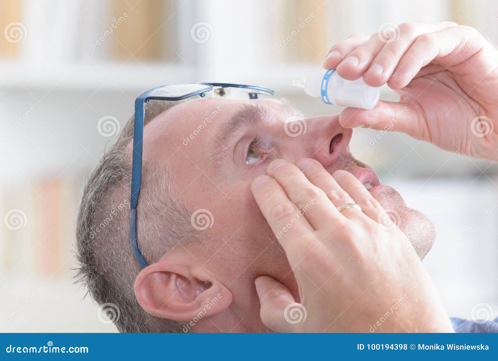 Man applying eye drops stock photo. Image of bottle - 100194398