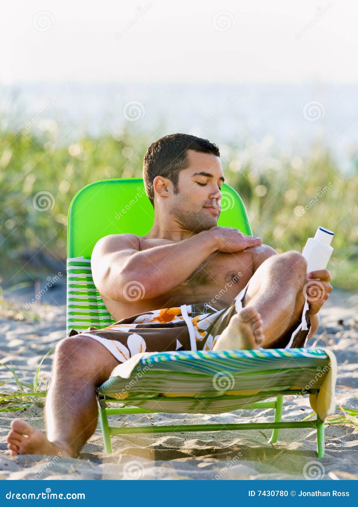 Man Applying Sunscreen Lotion at Beach Stock Photo - Image of scene ...