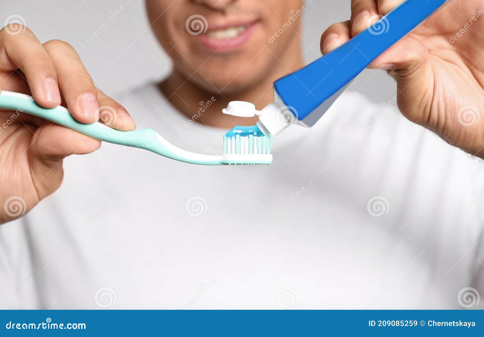 Man Applying Toothpaste on Brush Against Light Background, Closeup ...