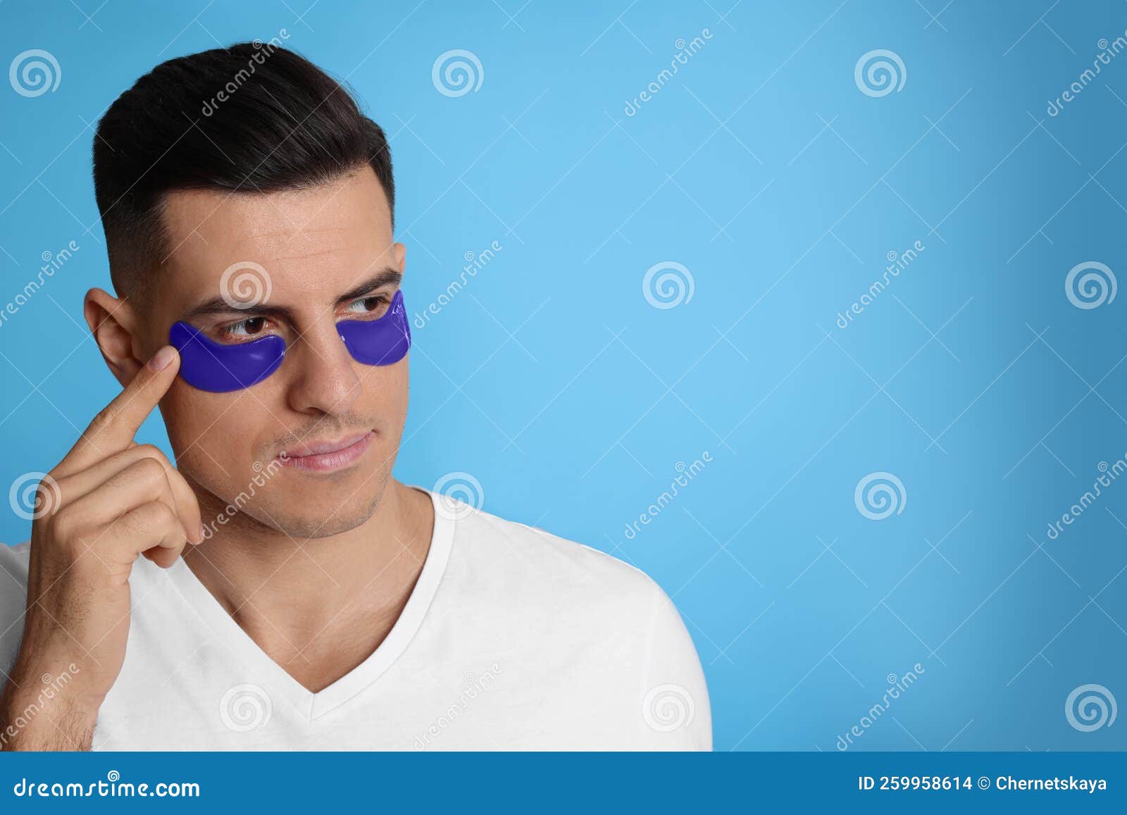 Man Applying Under Eye Patch on Light Blue Background. Space for Text ...