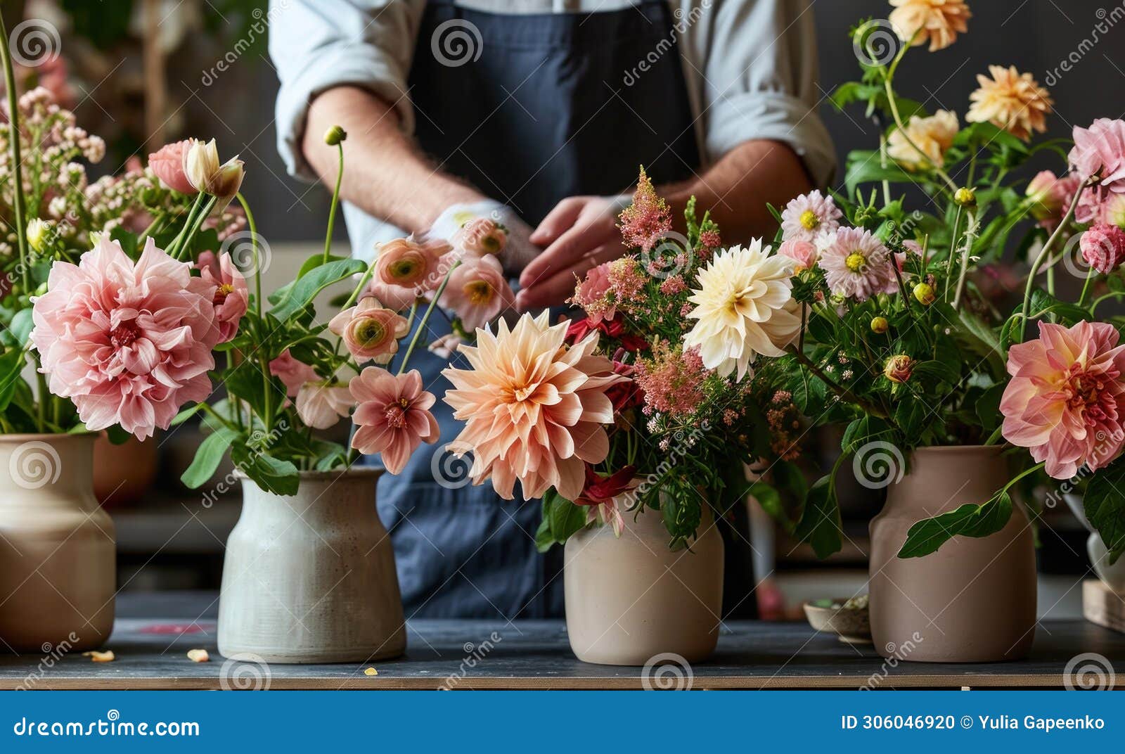 A Man in an Apron Arranging Flowers in Containers Stock Photo - Image ...