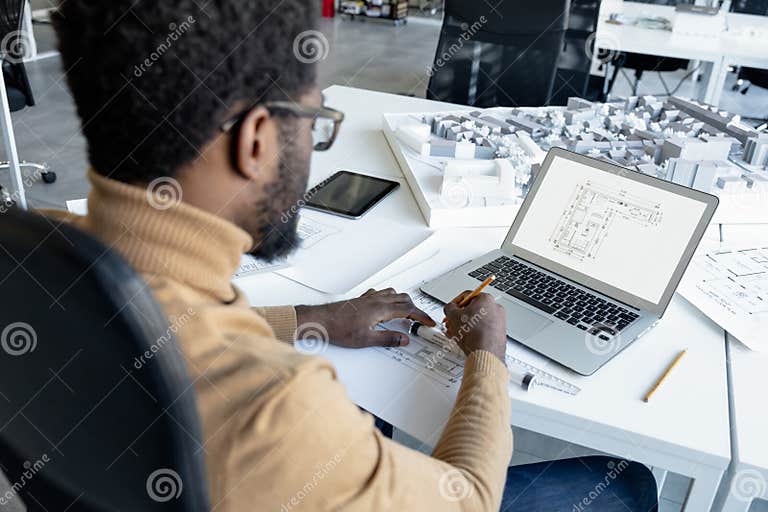 Man Architect Working with Software on Laptop Using Technical Drafts ...