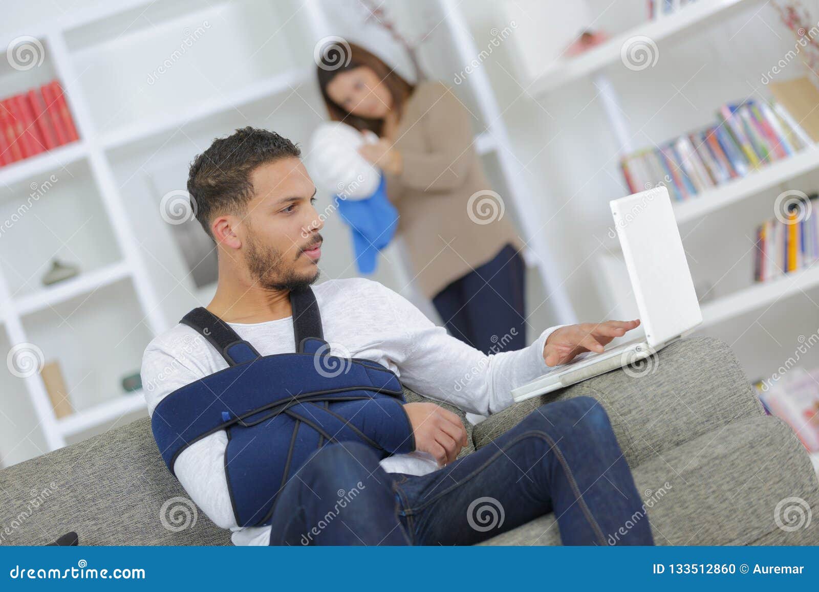 Man with Arm Injury Using Laptop Stock Photo - Image of male ...