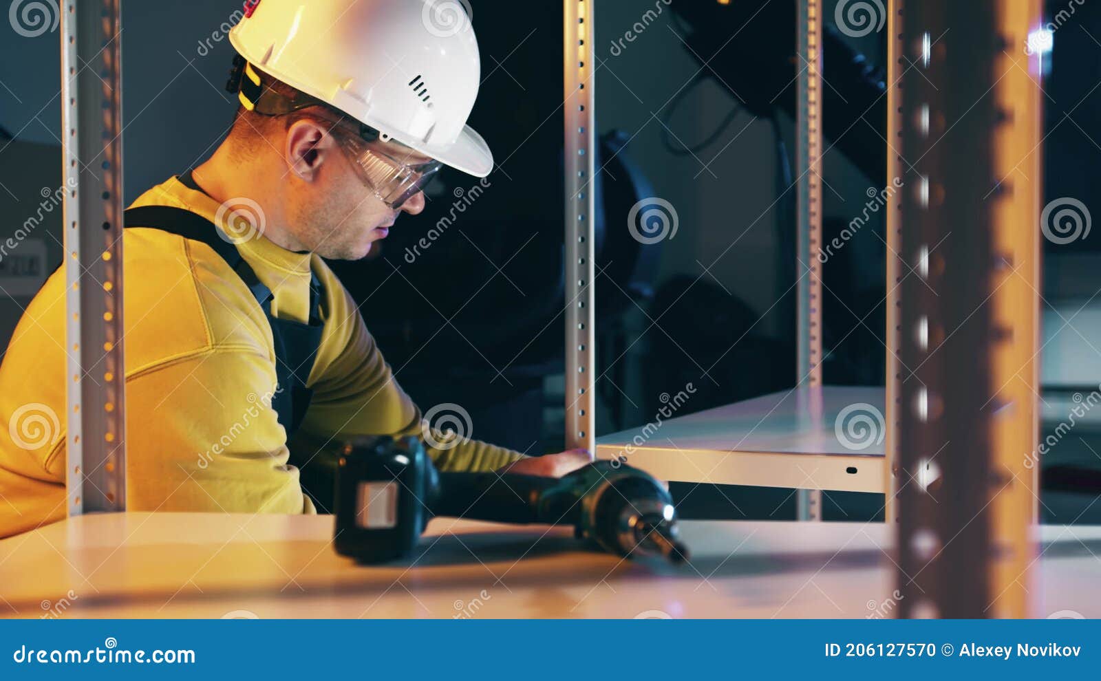 Man Wearing Hard Hat Assembles the Industrial Storage Shelf Rack Stock ...