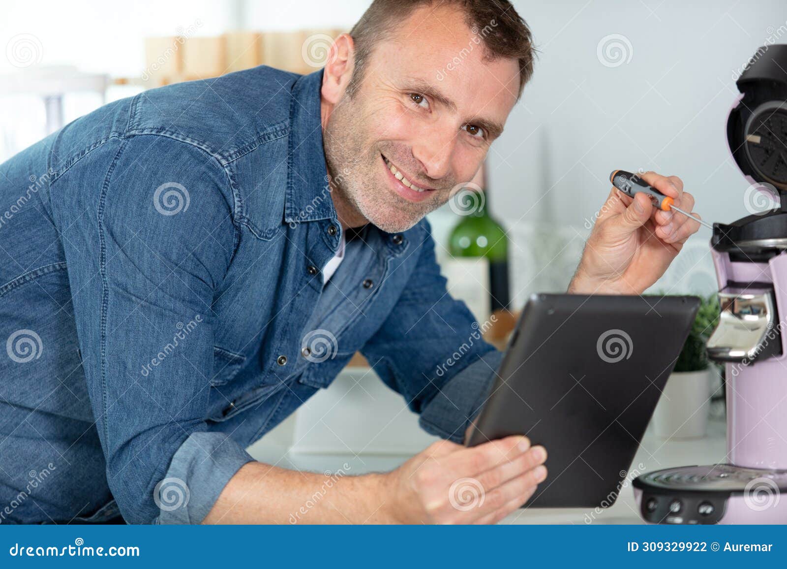 Man Assembling Appliance Following Instructions on Tablet Stock Photo ...