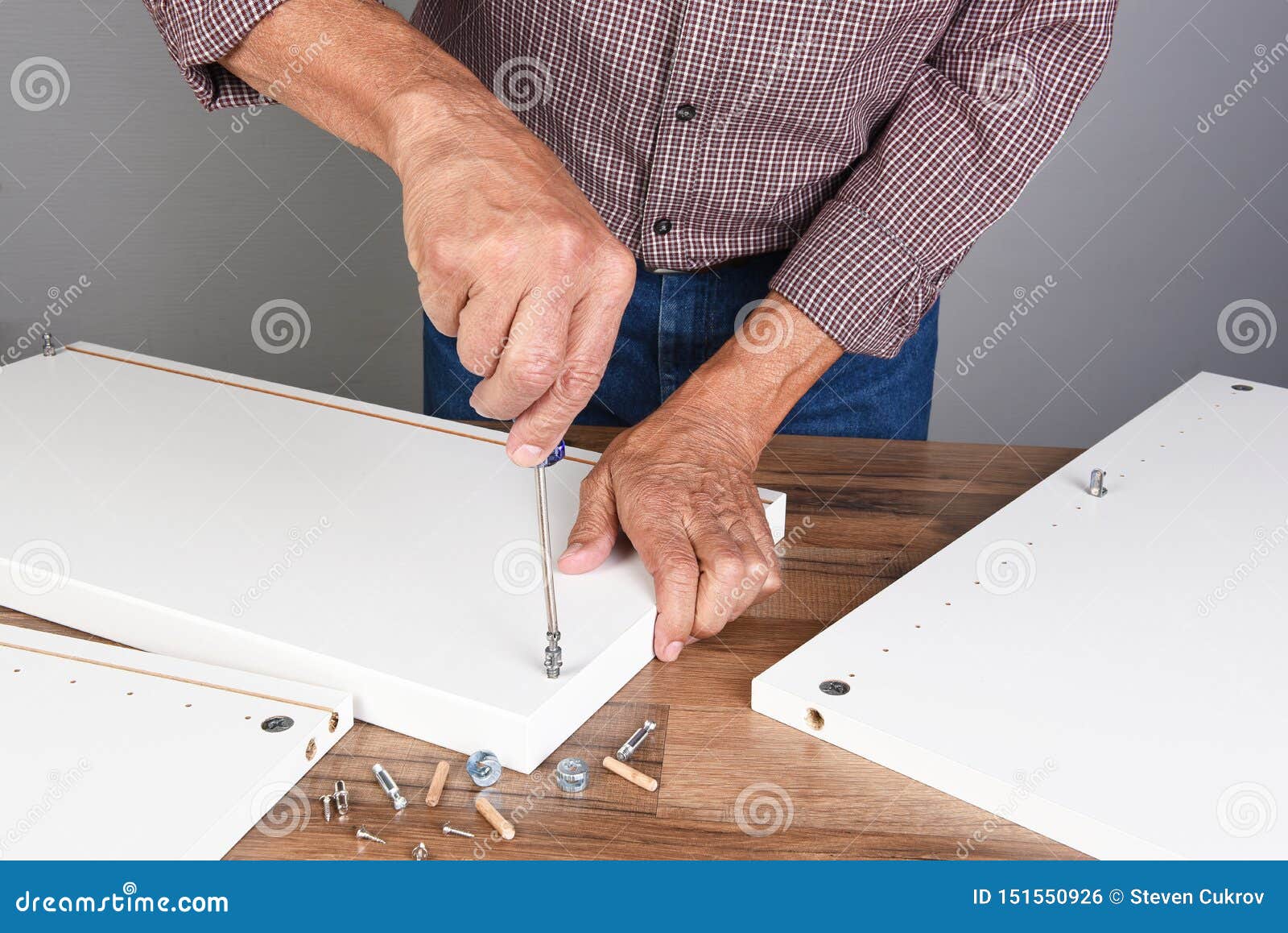 A Man Assembling A Diy Piece Of Furniture Person Is Using A