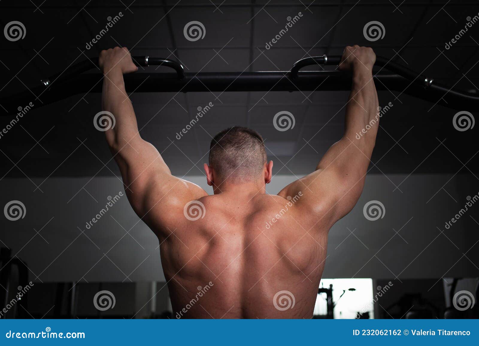 A Man Athlete Bodybuilder Pulls Up on His Hands, Builds Muscles, Does ...