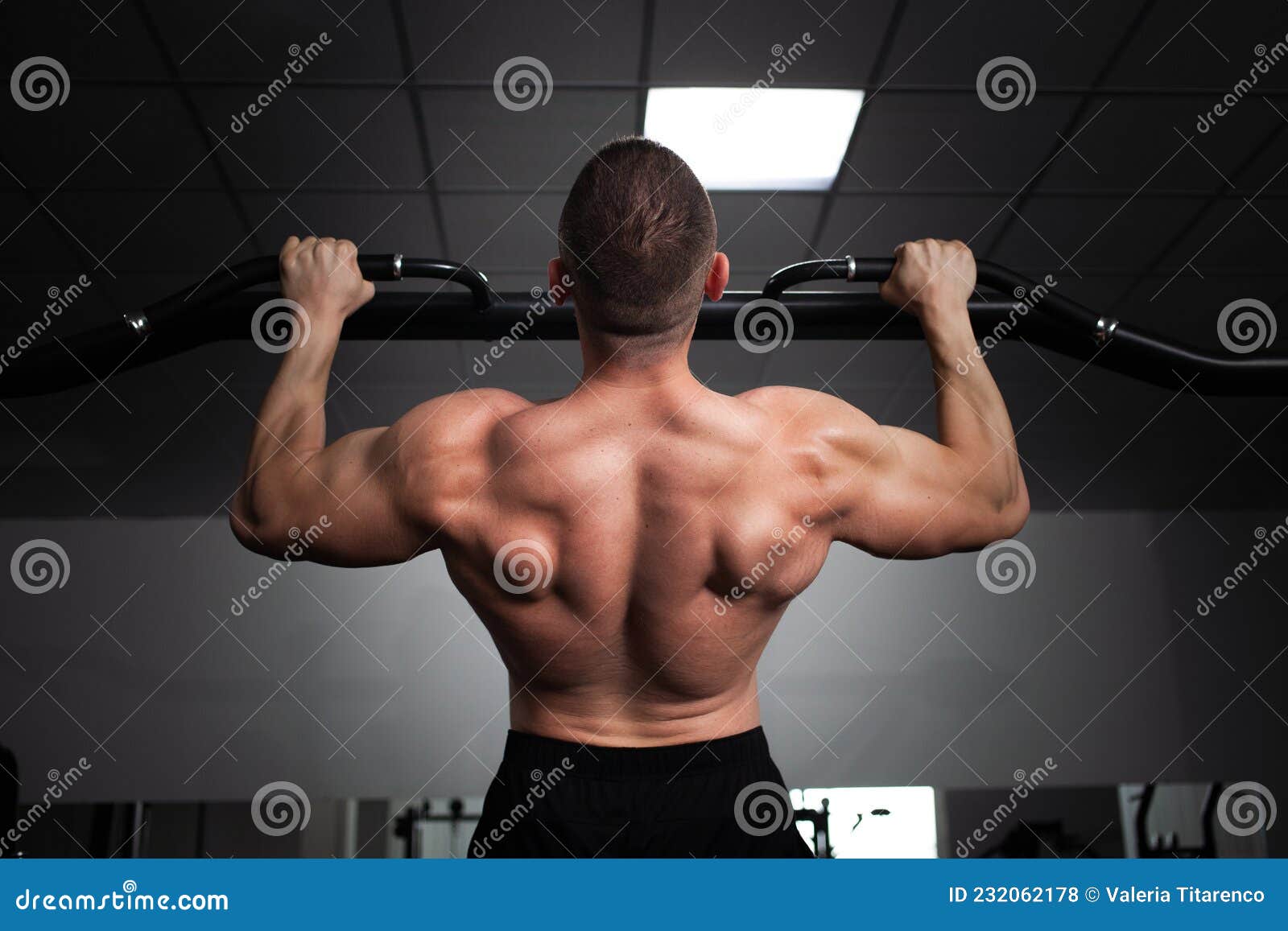 A Man Athlete Bodybuilder Pulls Up on His Hands, Builds Muscles, Does ...