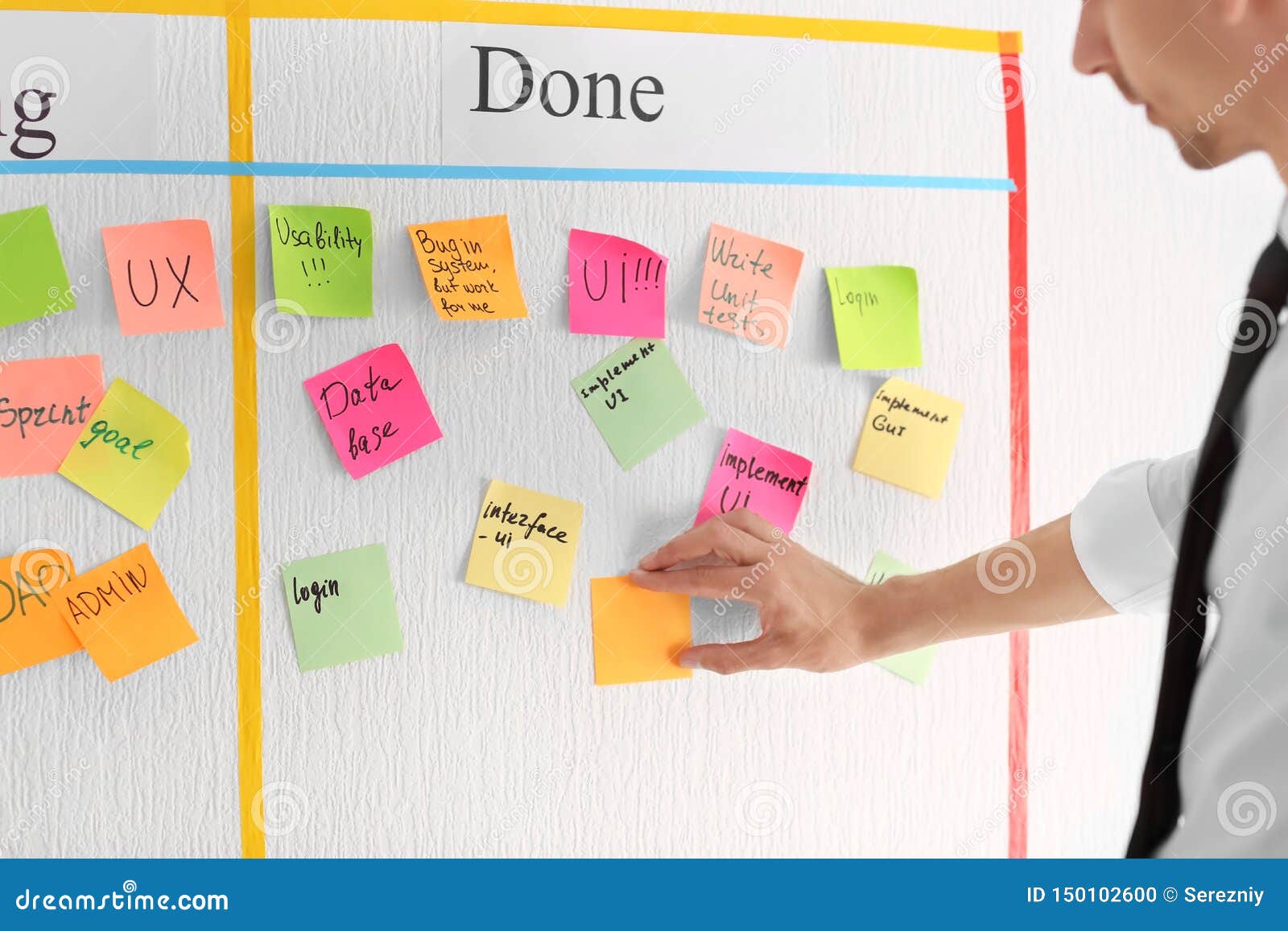 Man Attaching Sticky Note To Scrum Task Board in Office Stock Photo ...