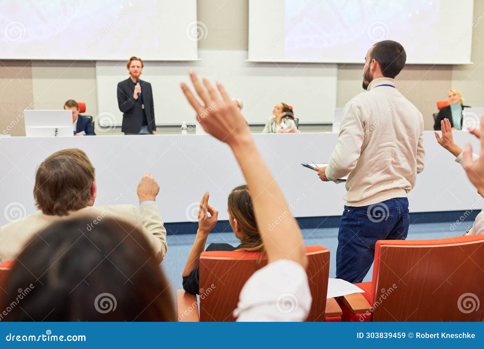 Man in Audience Asking Question To Speaker at Business Event Stock ... Man in Audience Asking Question To Speaker at Business Event Stock ...
